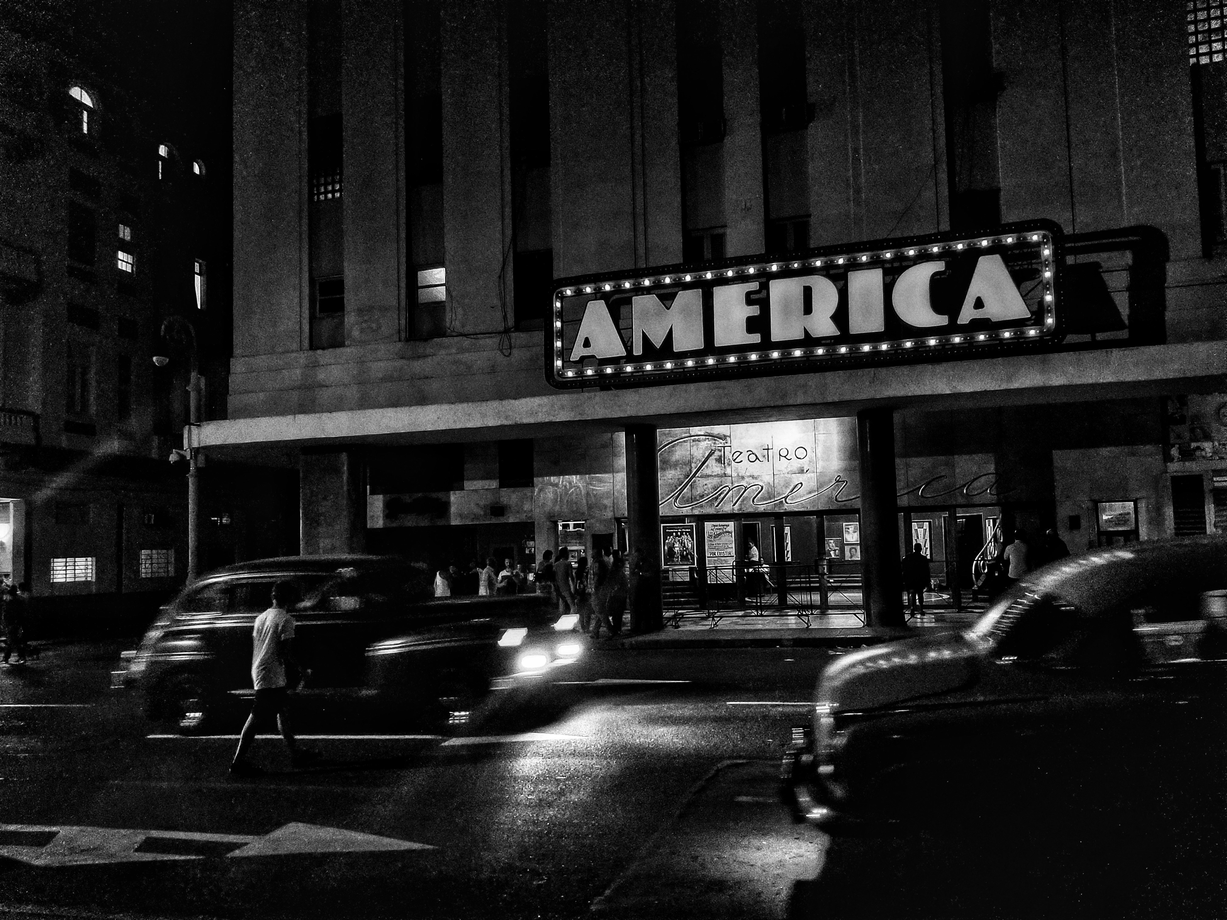 Neon Marvels: The America Theater in Night Traffic