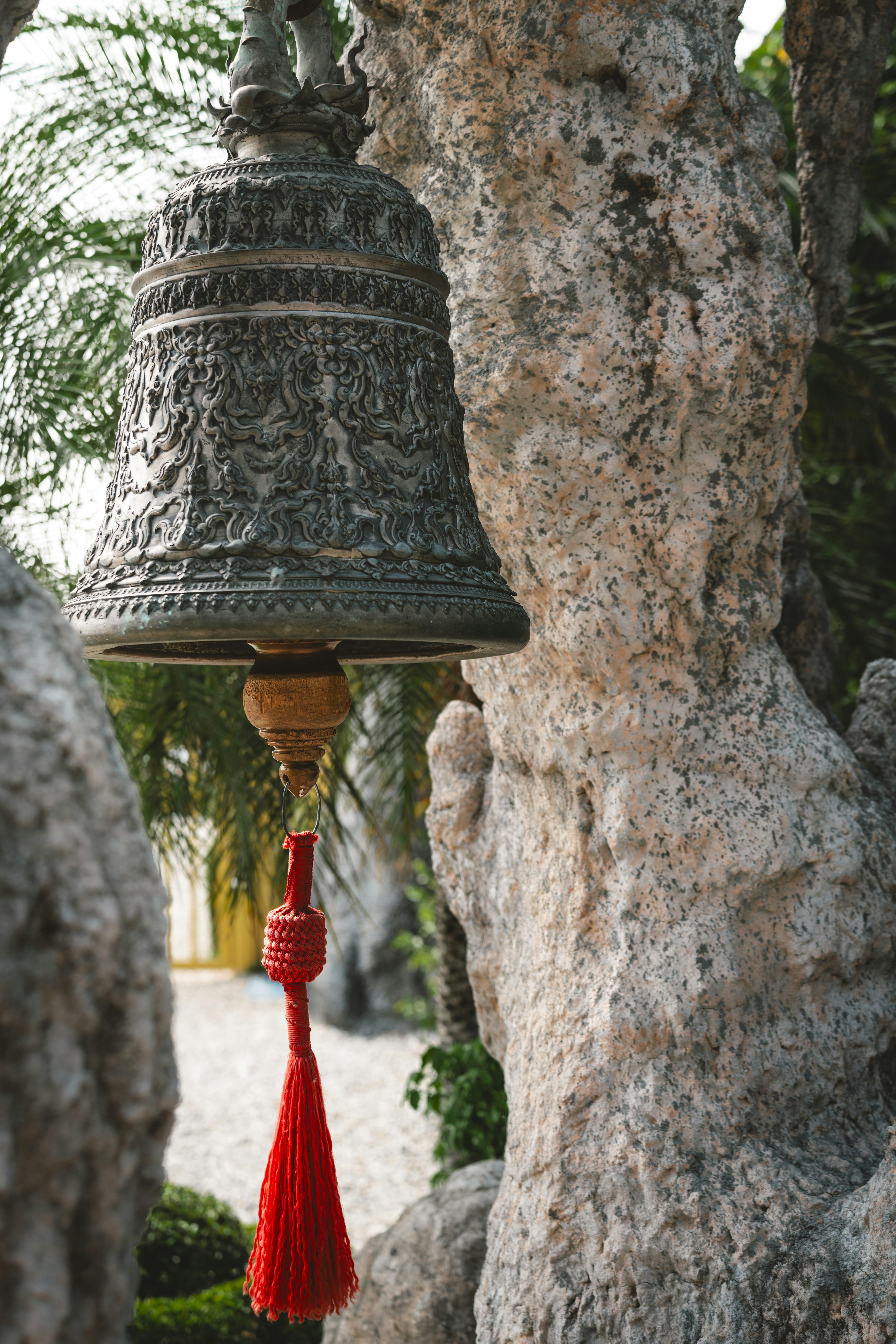 The Hanging Bell: An Ornate Relic Centered Between Stone Pines