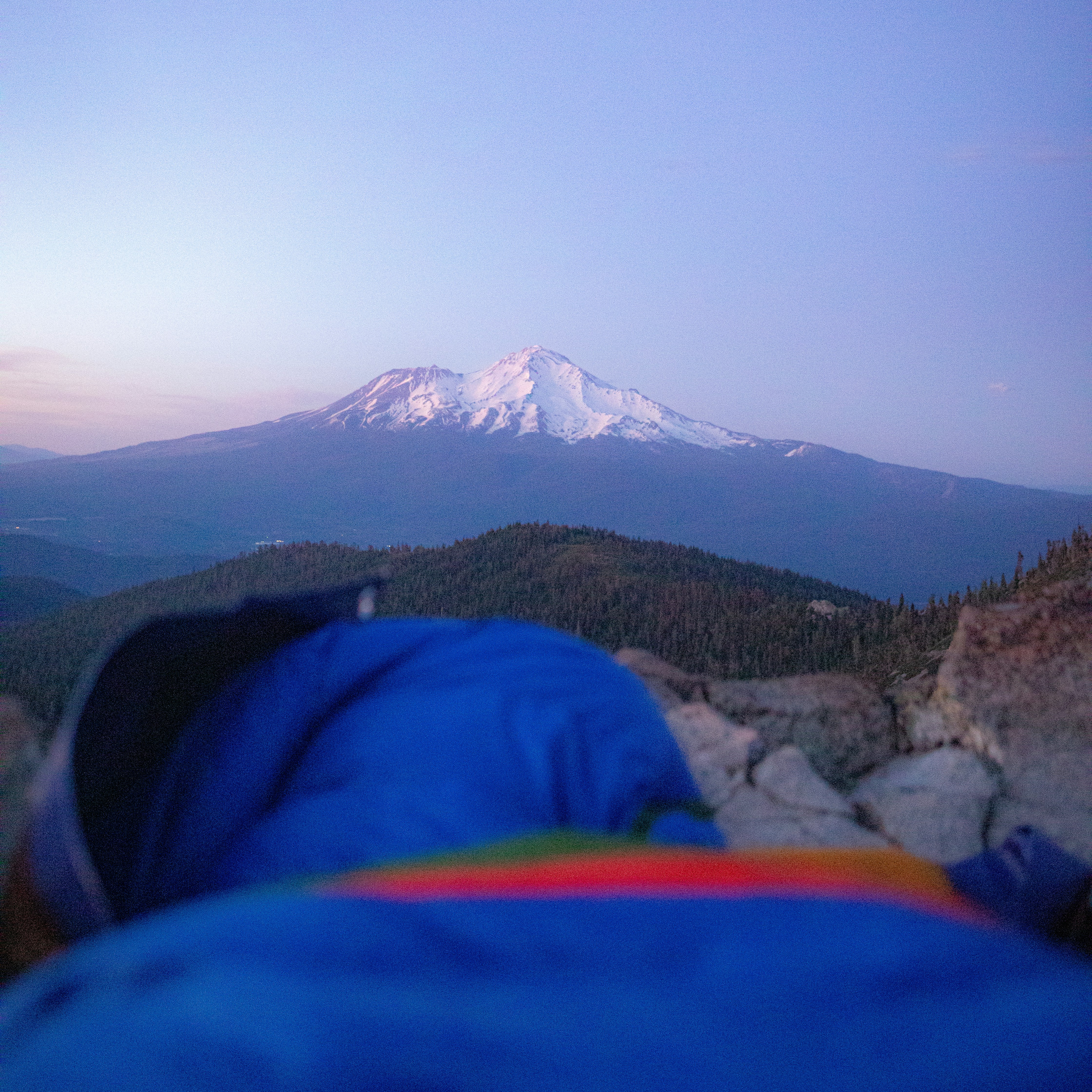 Snow-Capped Peak Beyond Camp Gear at Dusk