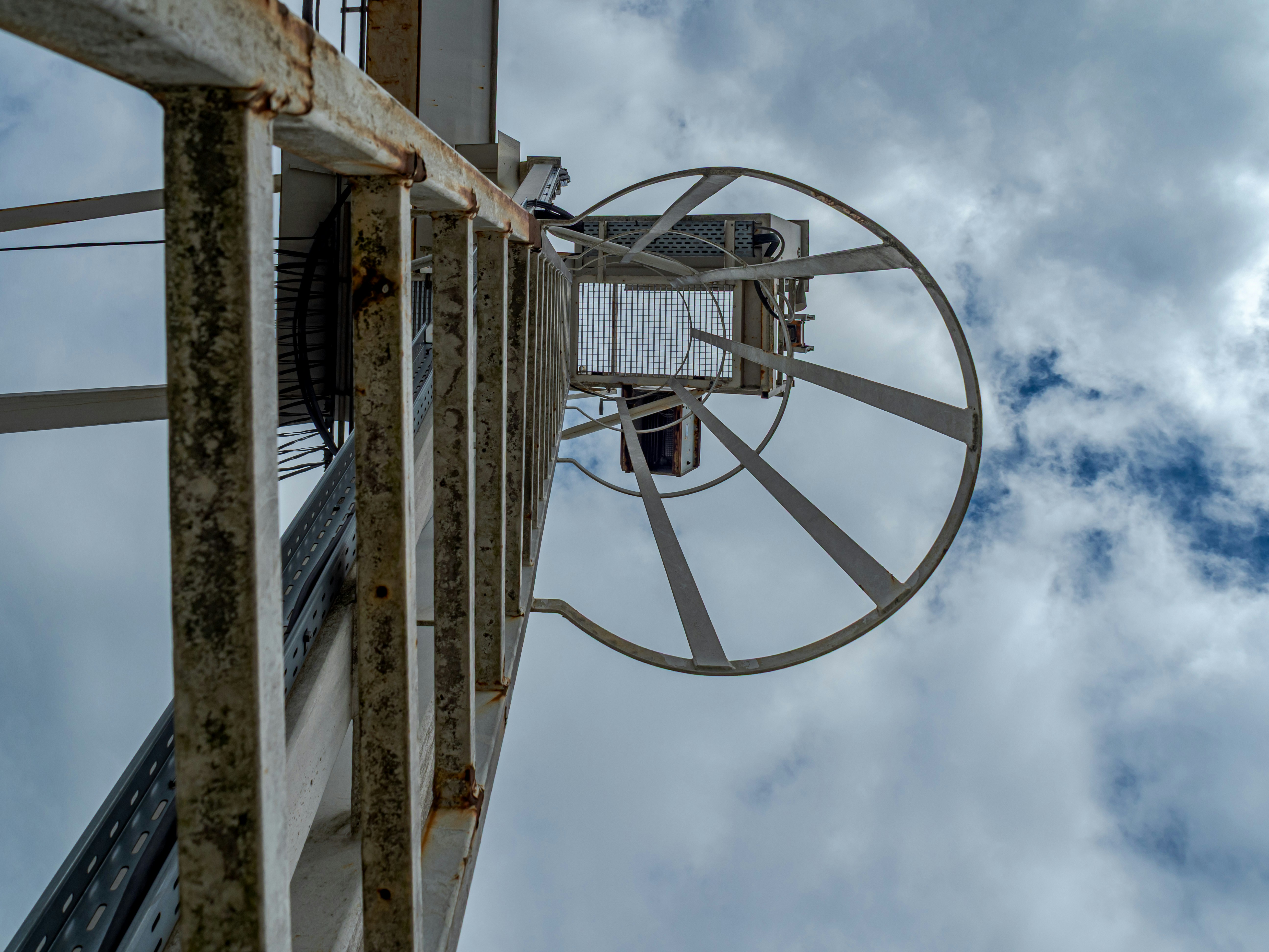 Rusted Watchtower Ascending into a Cloudy Sky