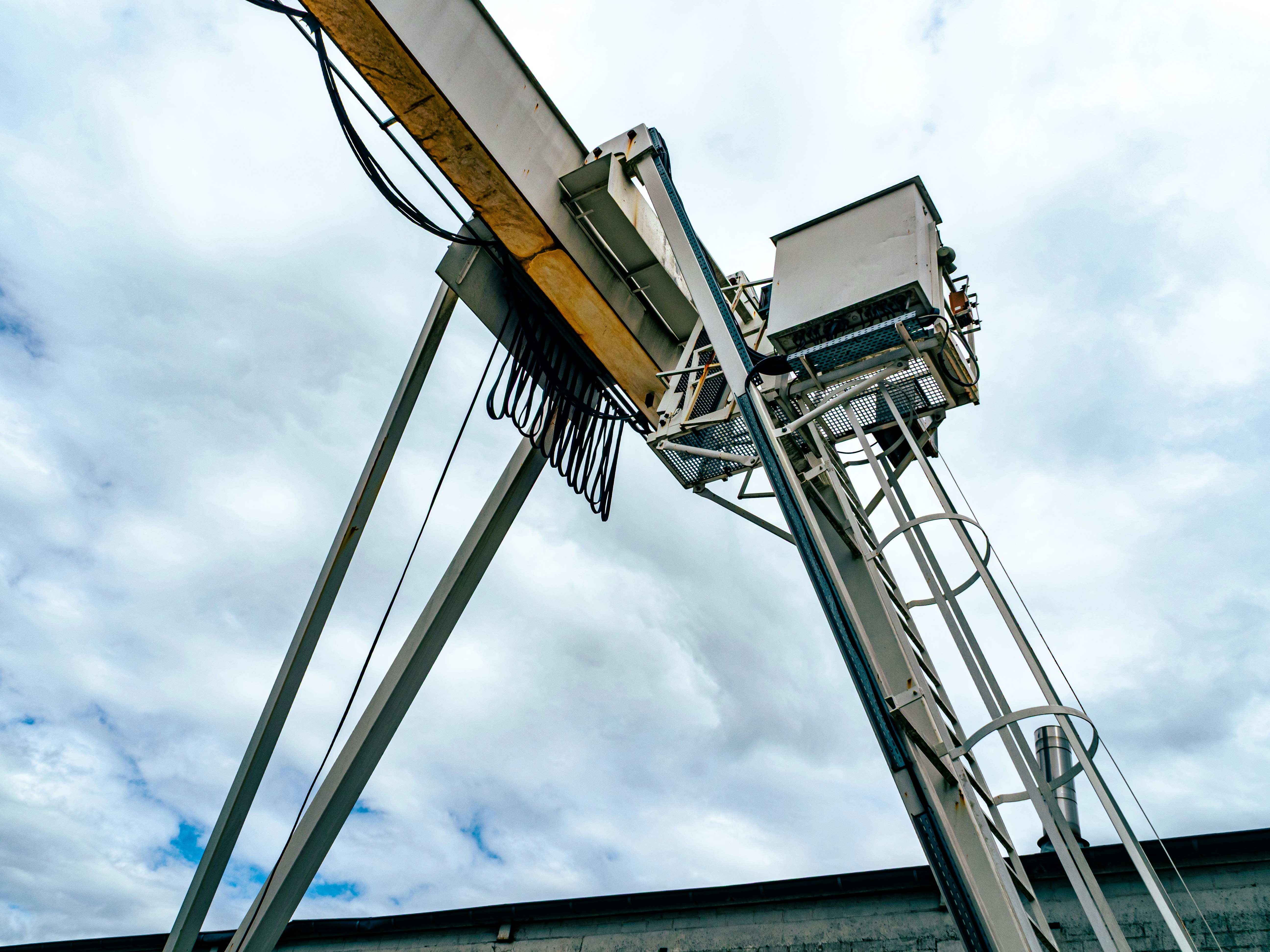 Crane Arm Ascendant: A Structural Portrait Against a Clouded Sky
