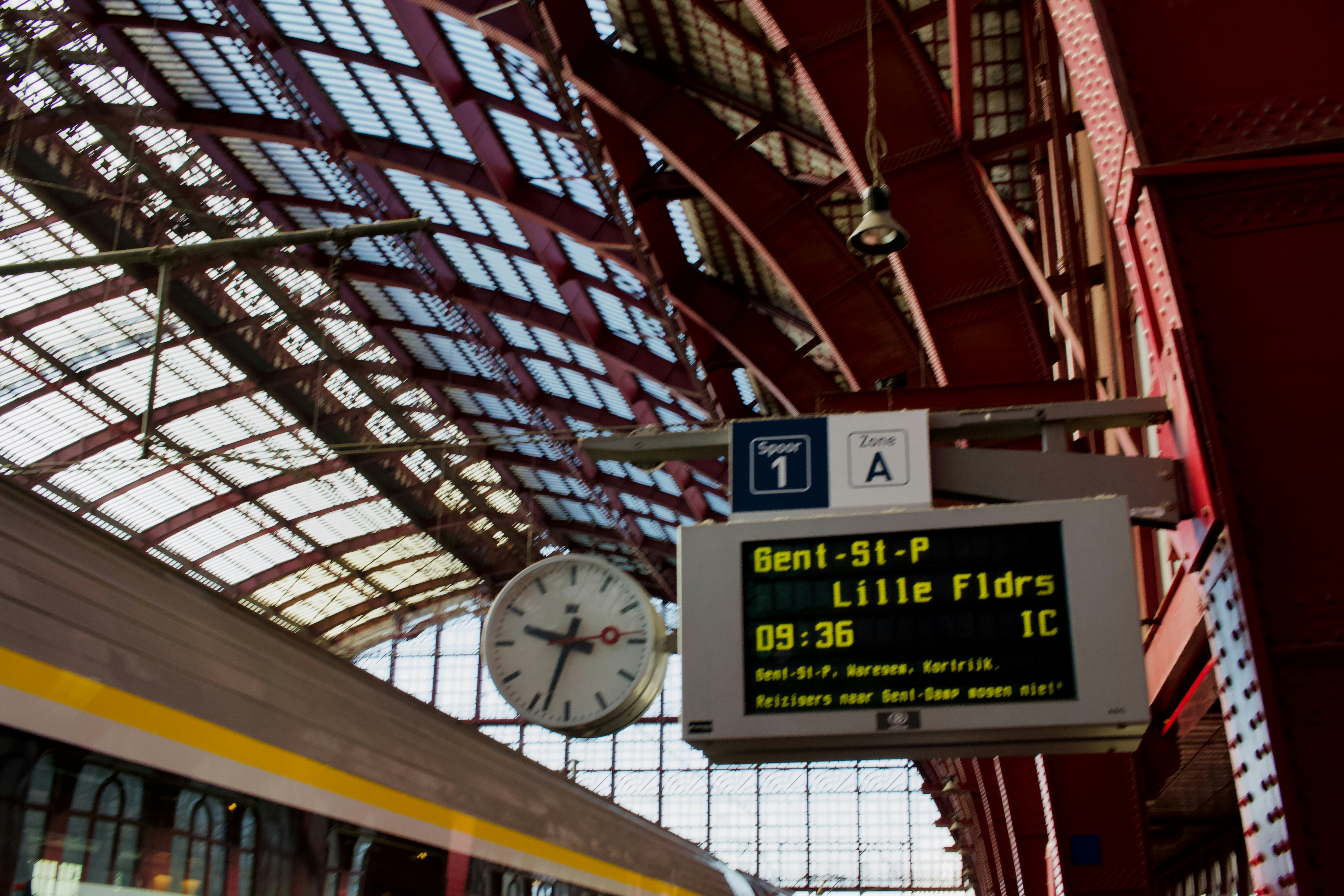 Waiting Clock and Sign at a Sunlit Train Station Roof