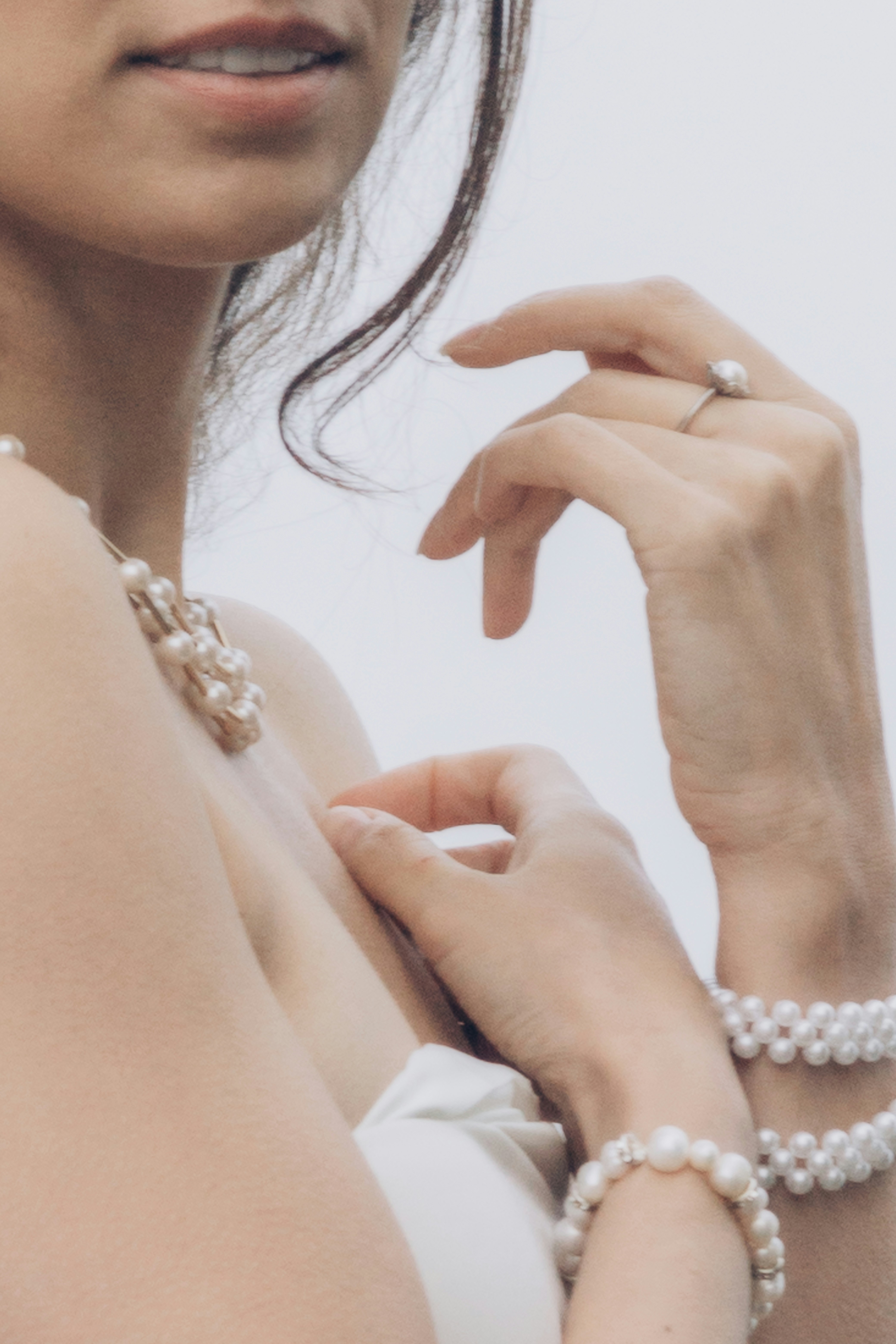 Woman wearing pearl necklace, bracelet, and ring