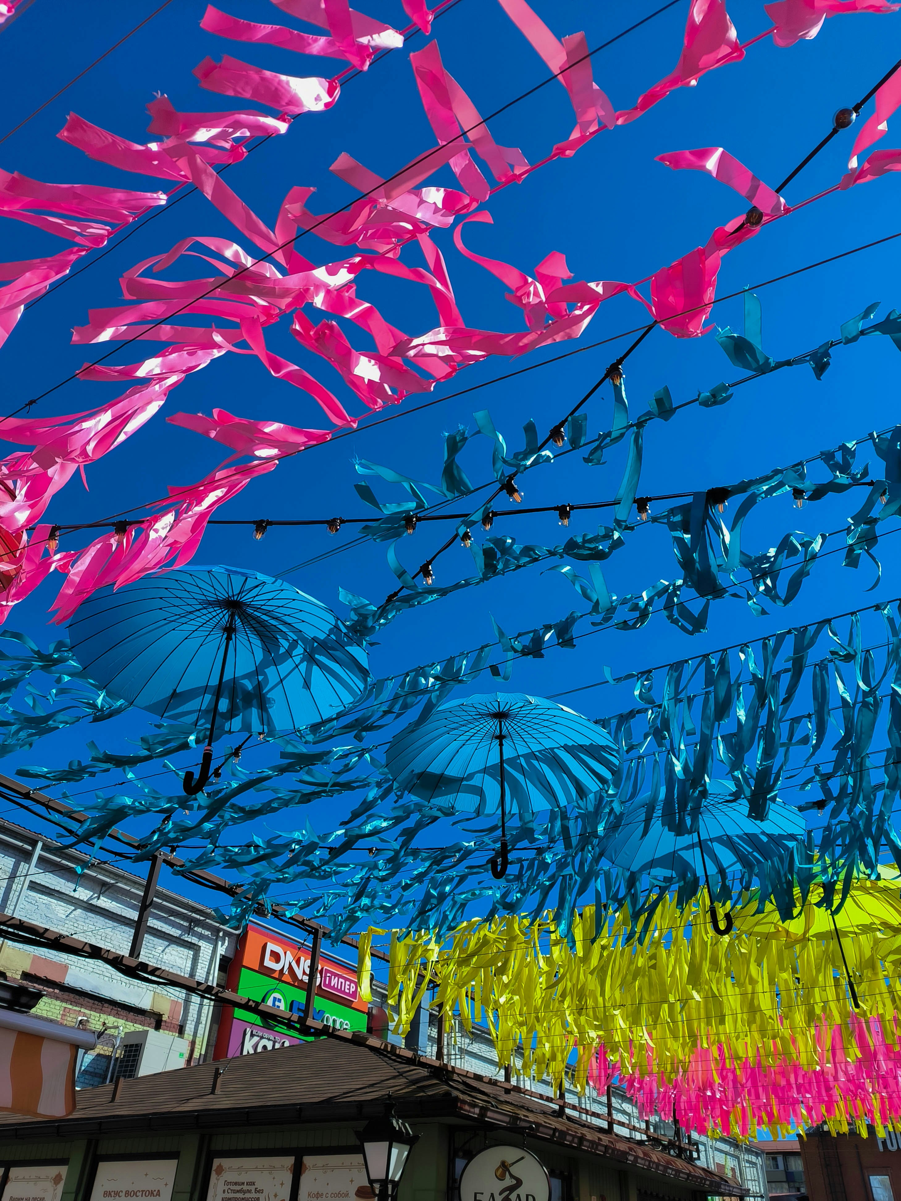Flag Streamers Over Blue Sky: A Festive Alley in Sunlit Color