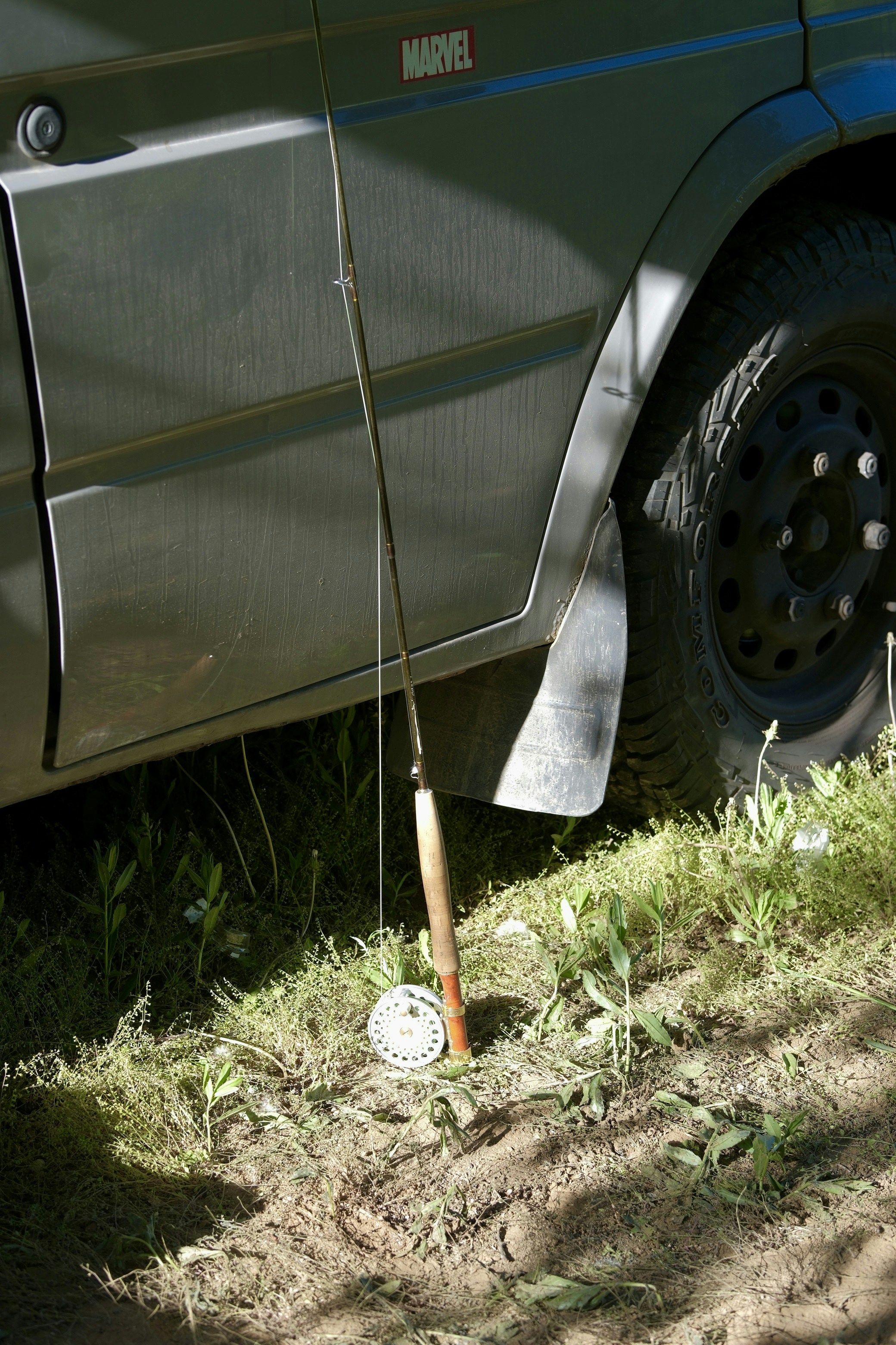 Pole and Van: A Quiet Fishing Moment by a Weathered Van