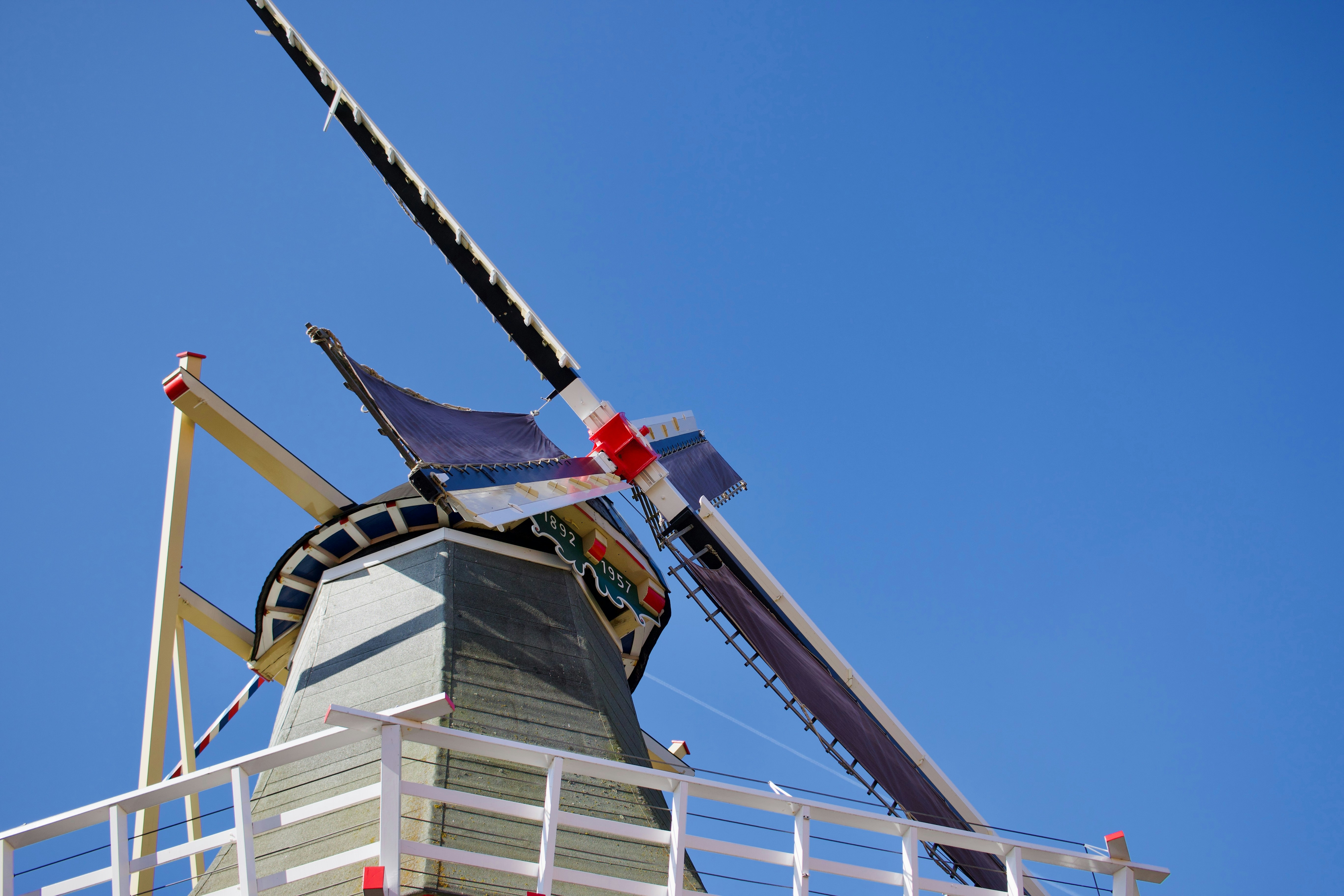 Top of the Pier: An Oceanic Windmill Crest Against a Clear Blue Sky