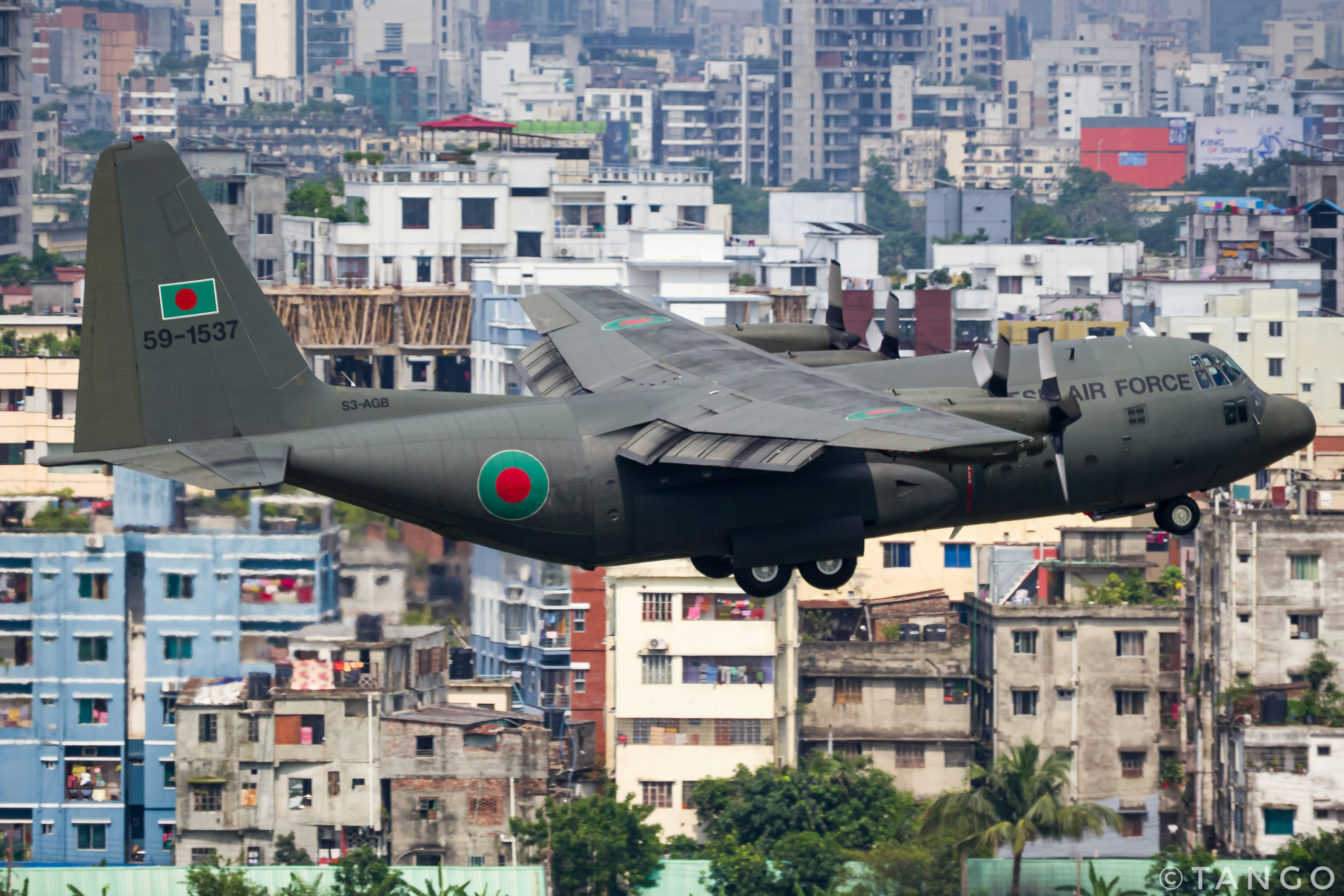Rugged transport in a concrete sea: a C-130-like silhouette over a dense cityscape