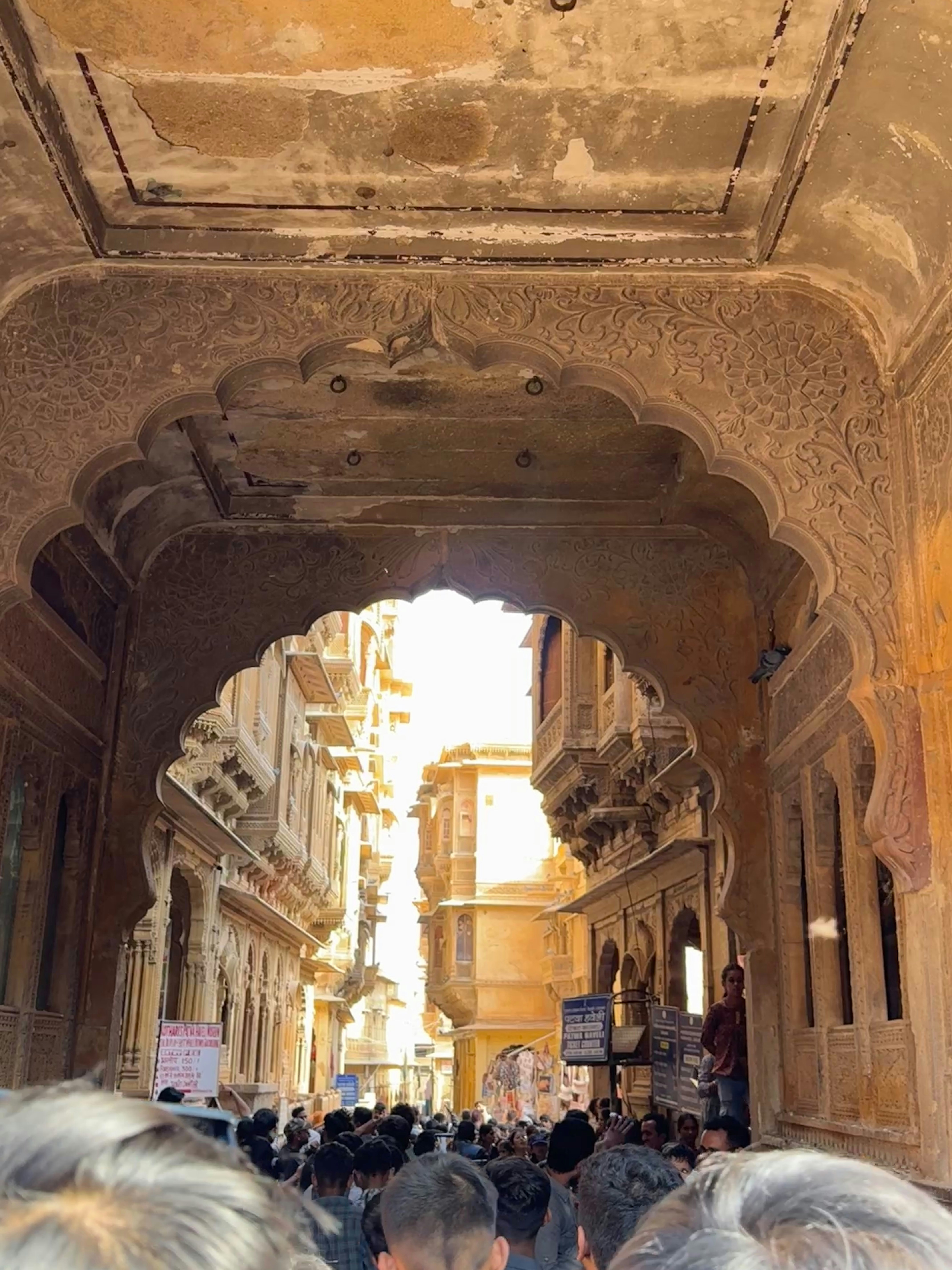 Archway Babel: A Sunlit Street Through Historic Carved Lattice
