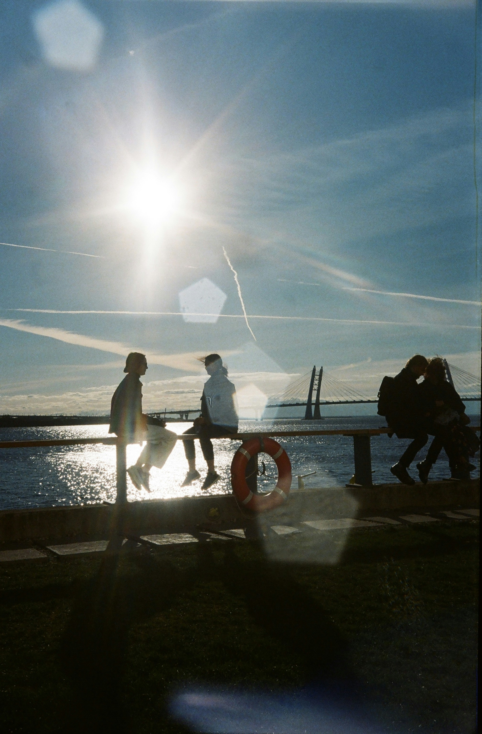 Sunlit Moments by the Waterfront: Silhouettes Against a Rising Tide