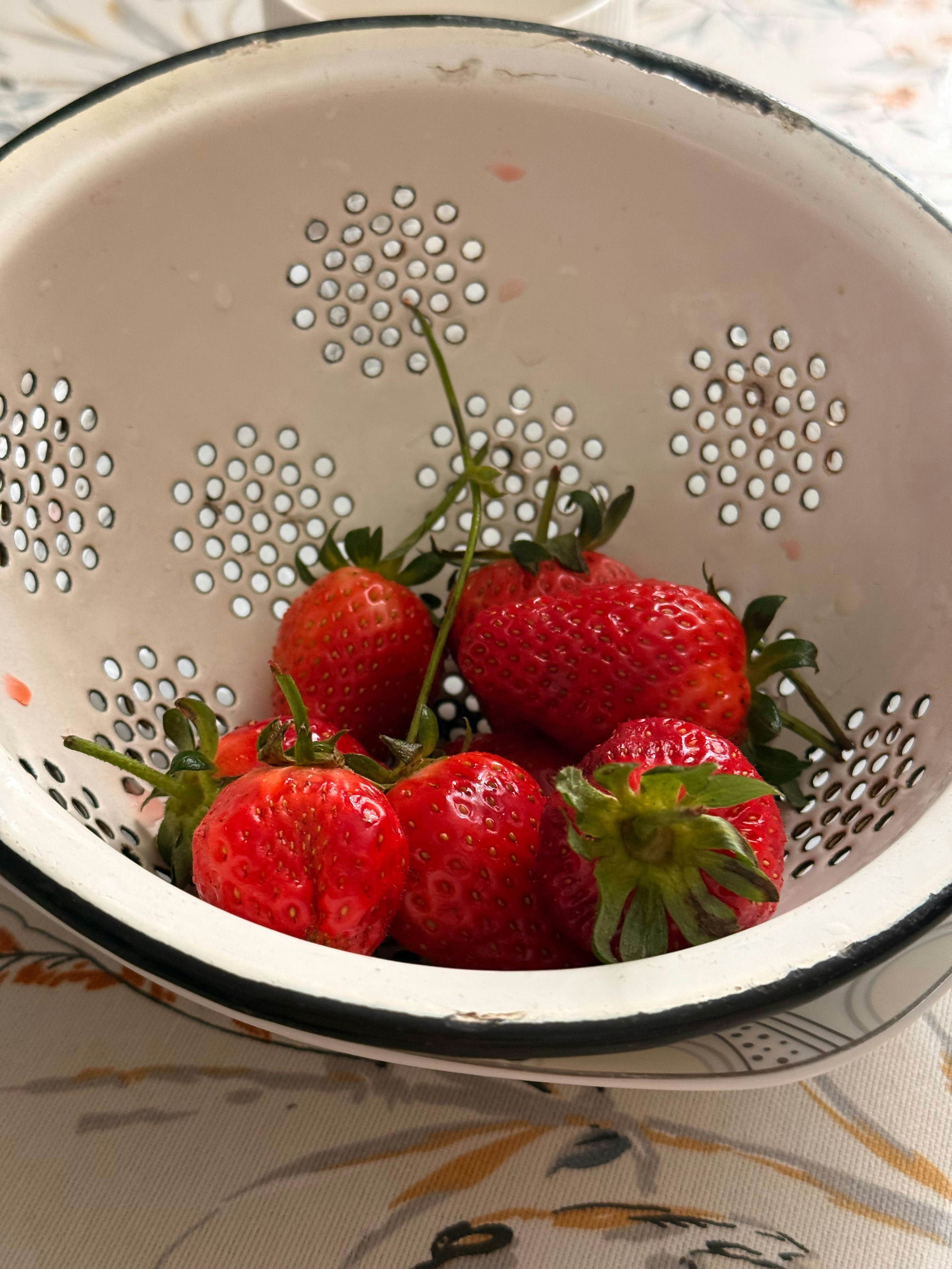 Strawberries in a Vintage Colander: Fresh Red Gems in Perforated Light
