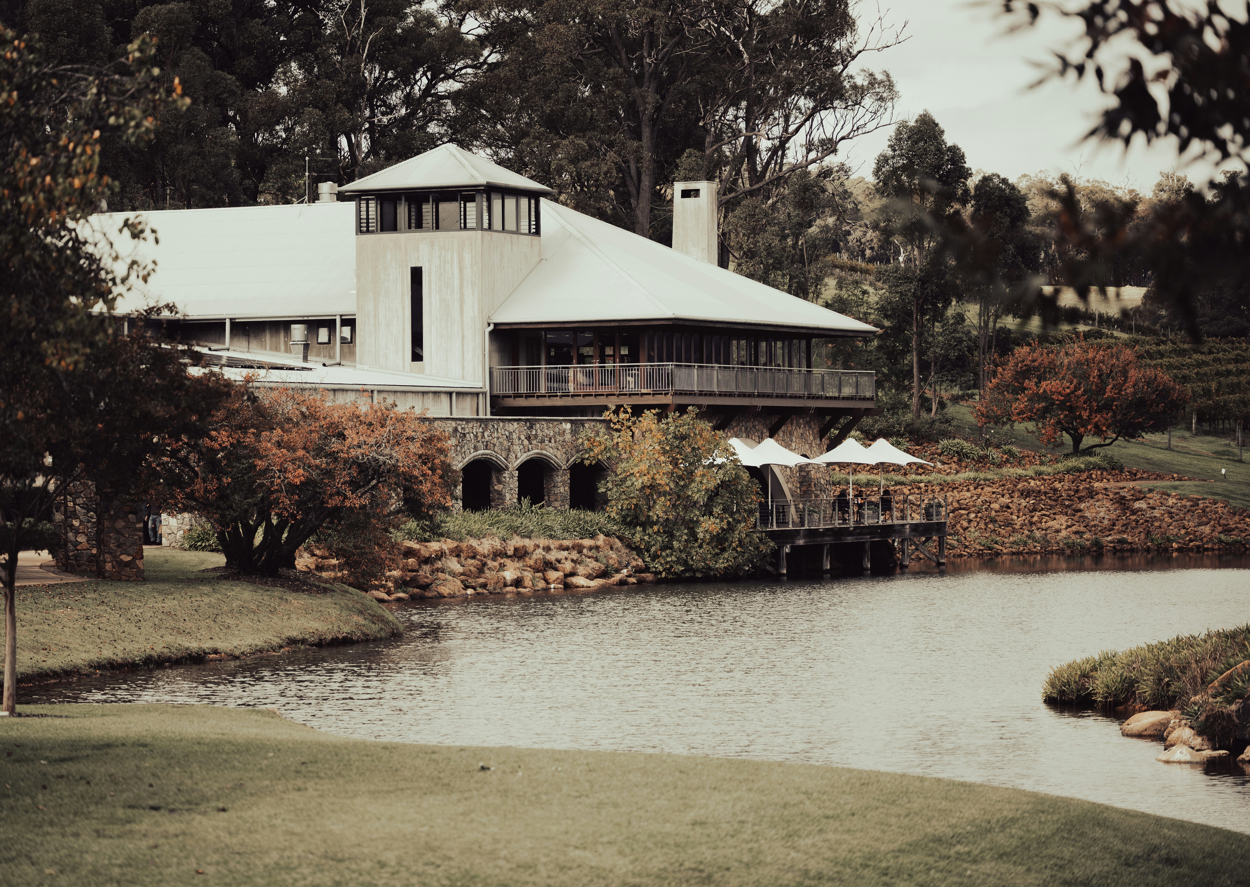 Modernist lakeside lodge framed by autumnal trees