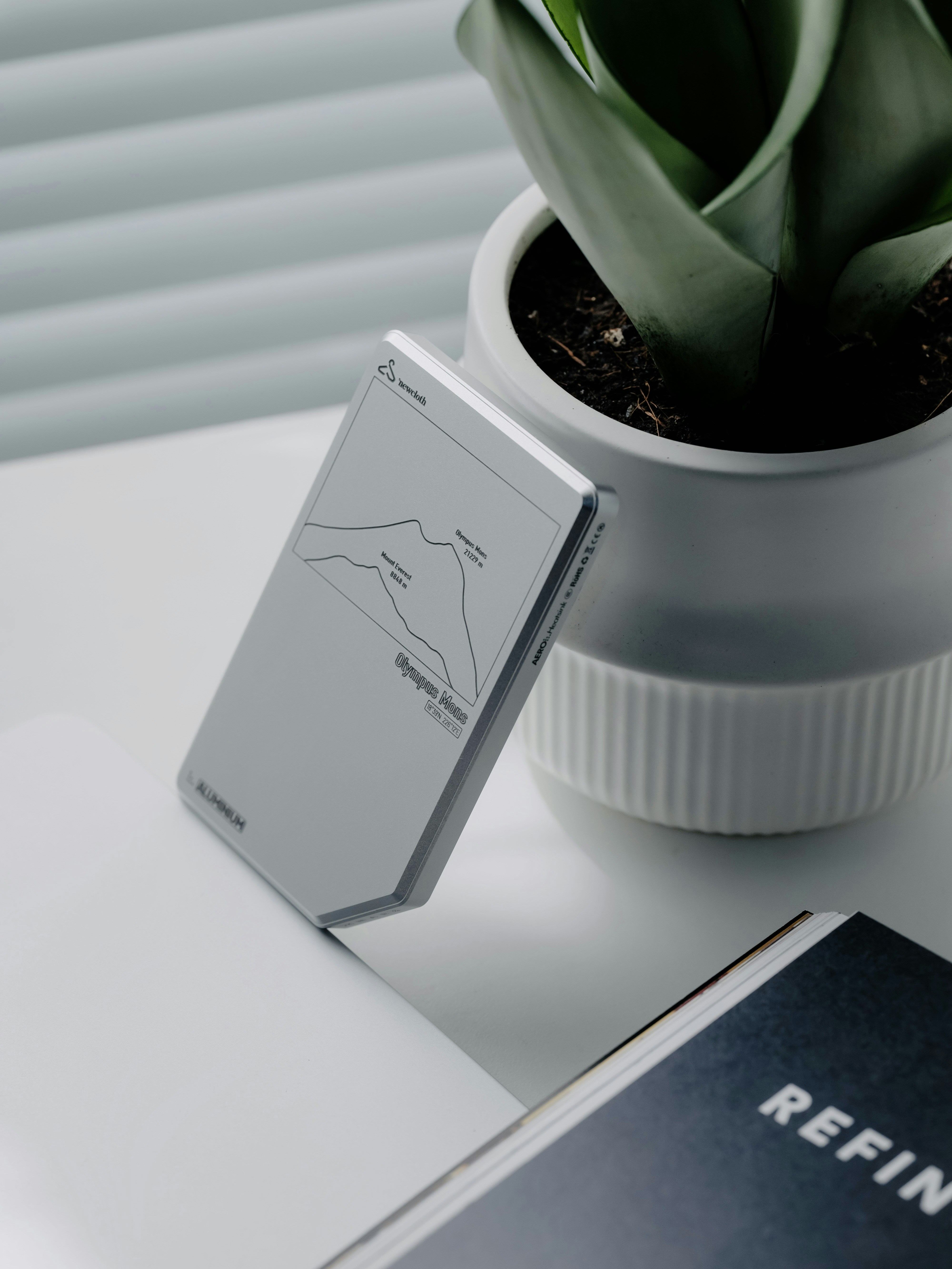 Compact E-reader Stand Hovering Above a Desk Plant