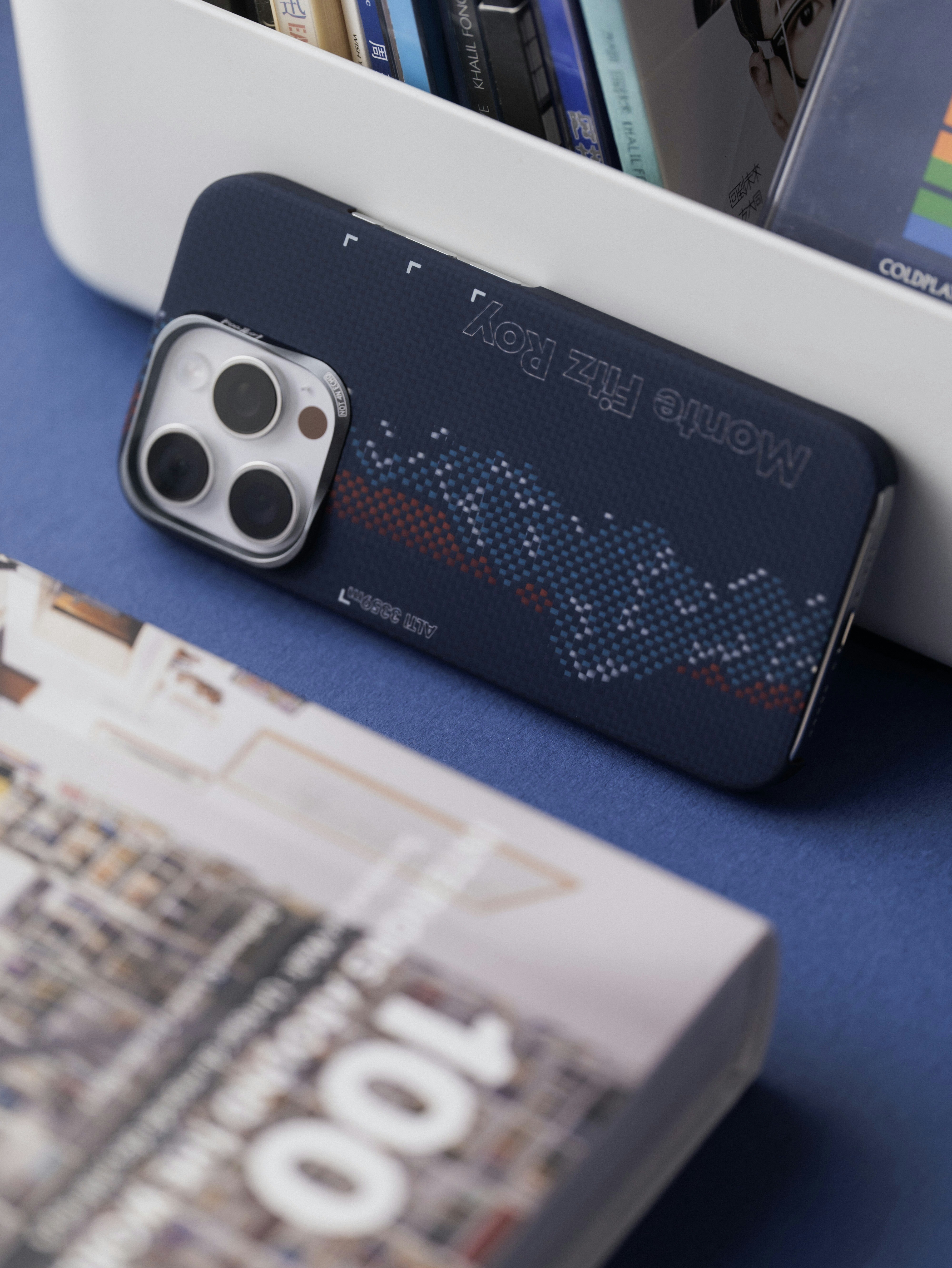World-map graphic case resting beside a modern smartphone on a blue display