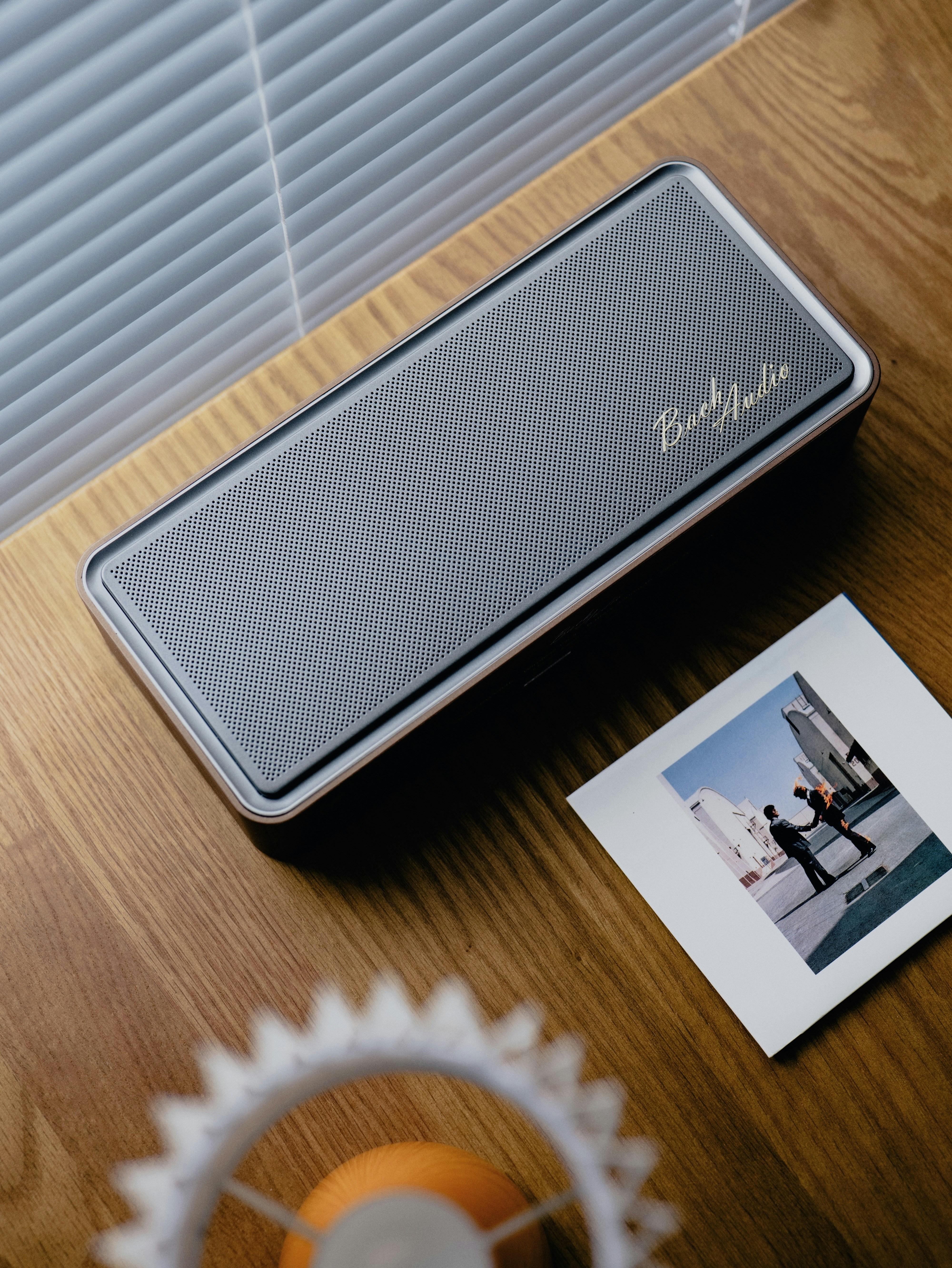 Soundscape on a Wooden Desk: A Portable Speaker and Polaroid Snapshot