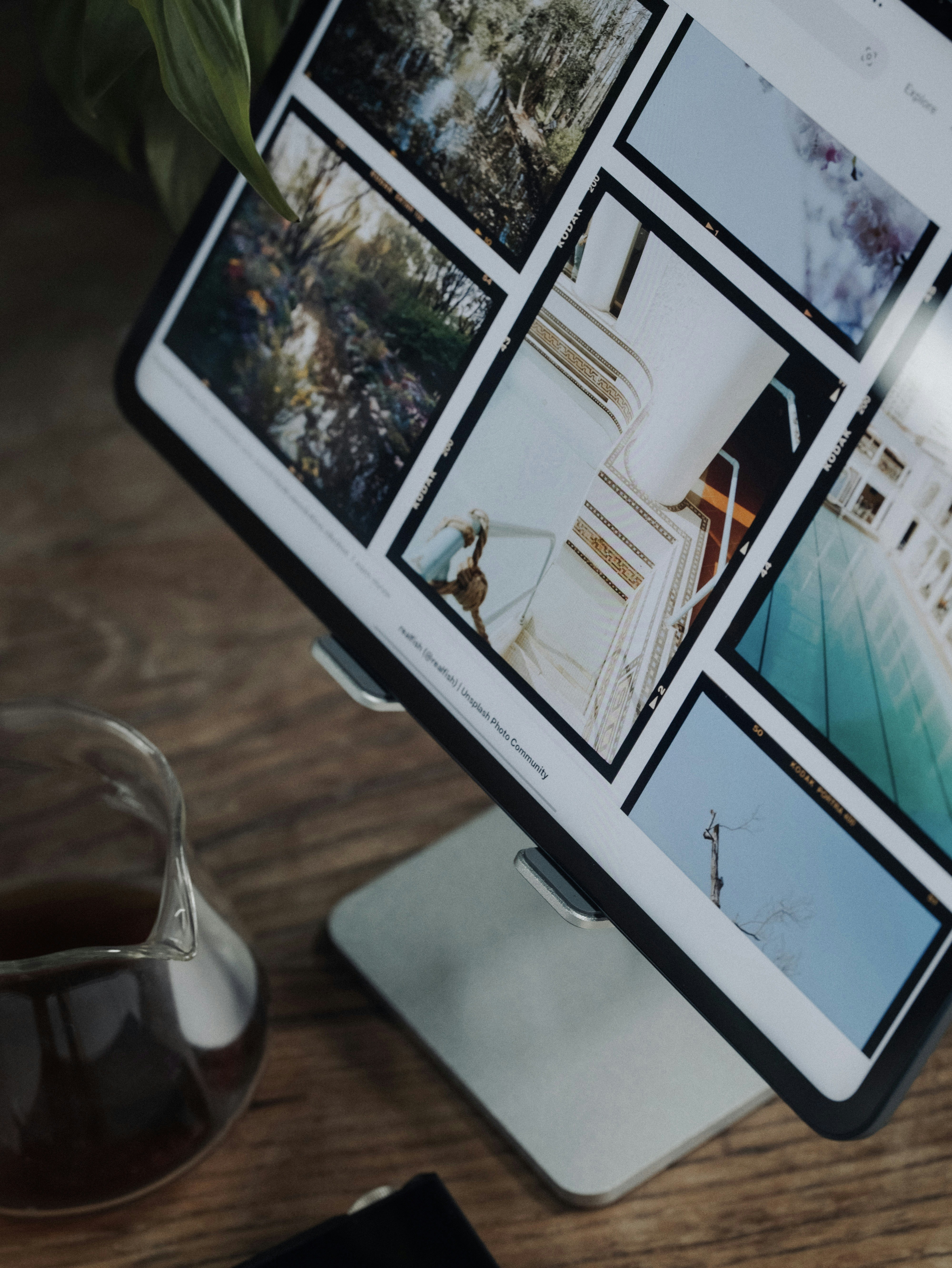Tablet displaying various photos on a wooden surface.