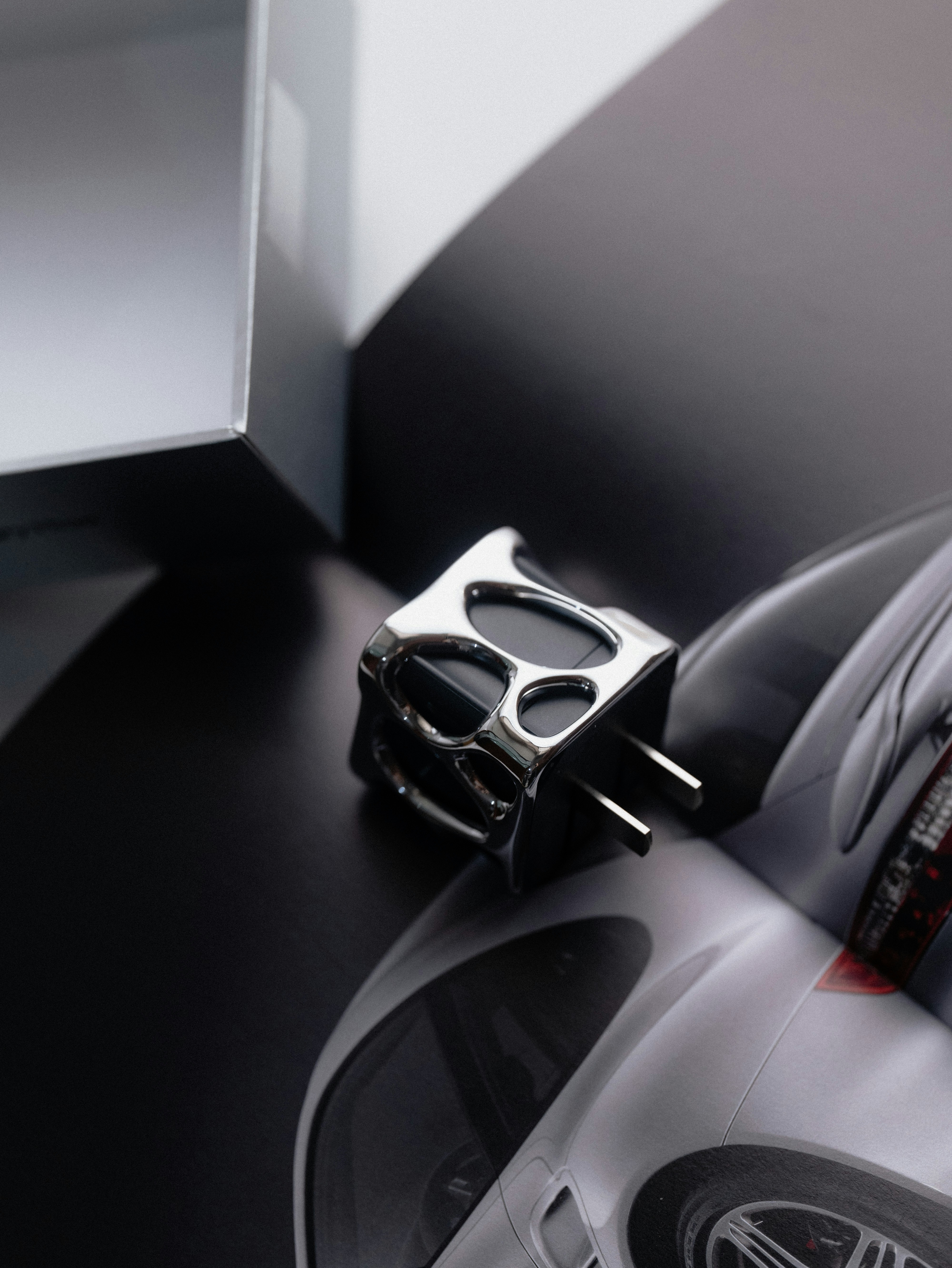 Chrome Connector: A Close-Up of a Metal Cube and an Automotive Part