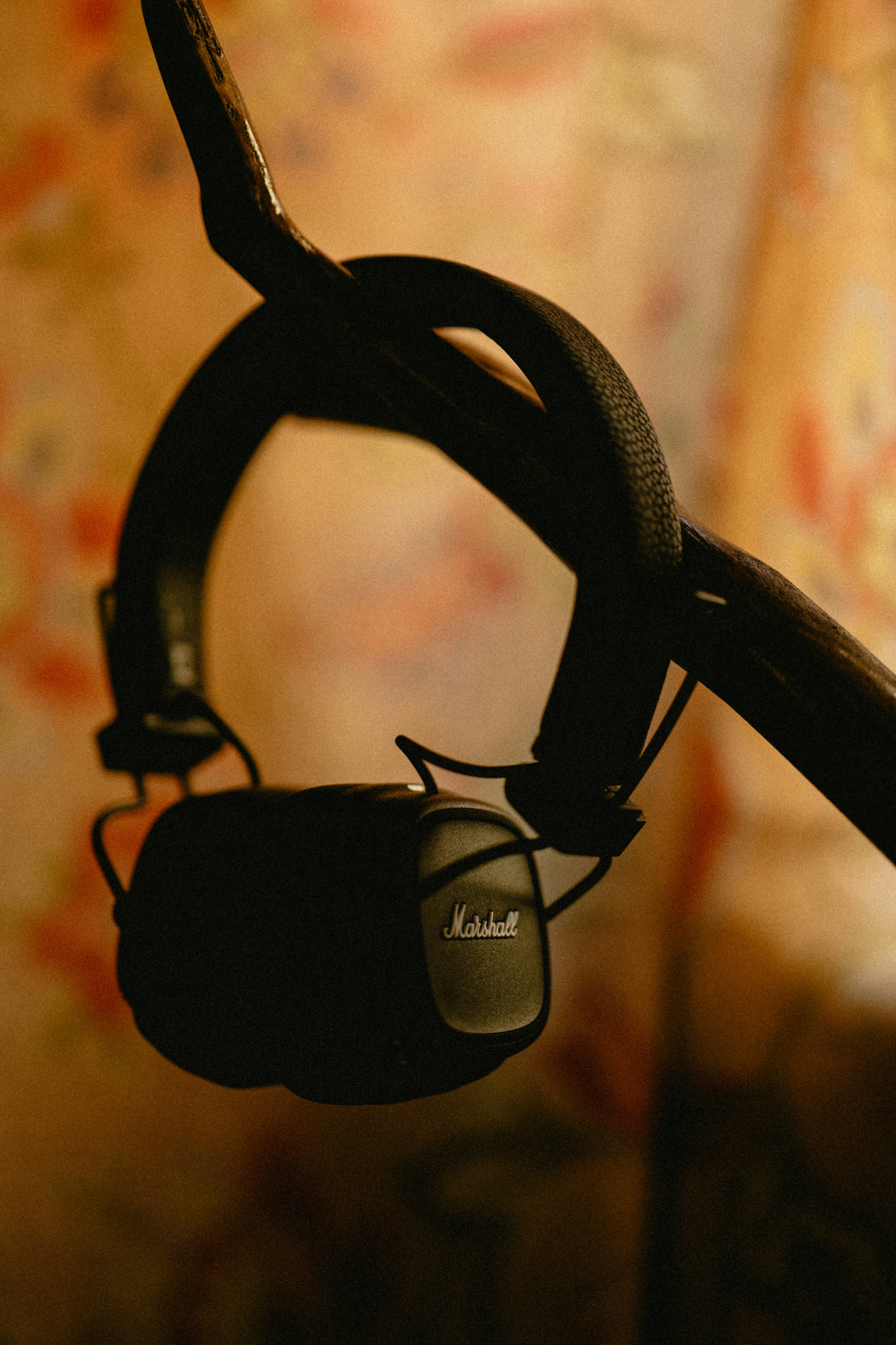 Muted Studio Echo: Marshall Headphones Gracing a Dappled Curtain