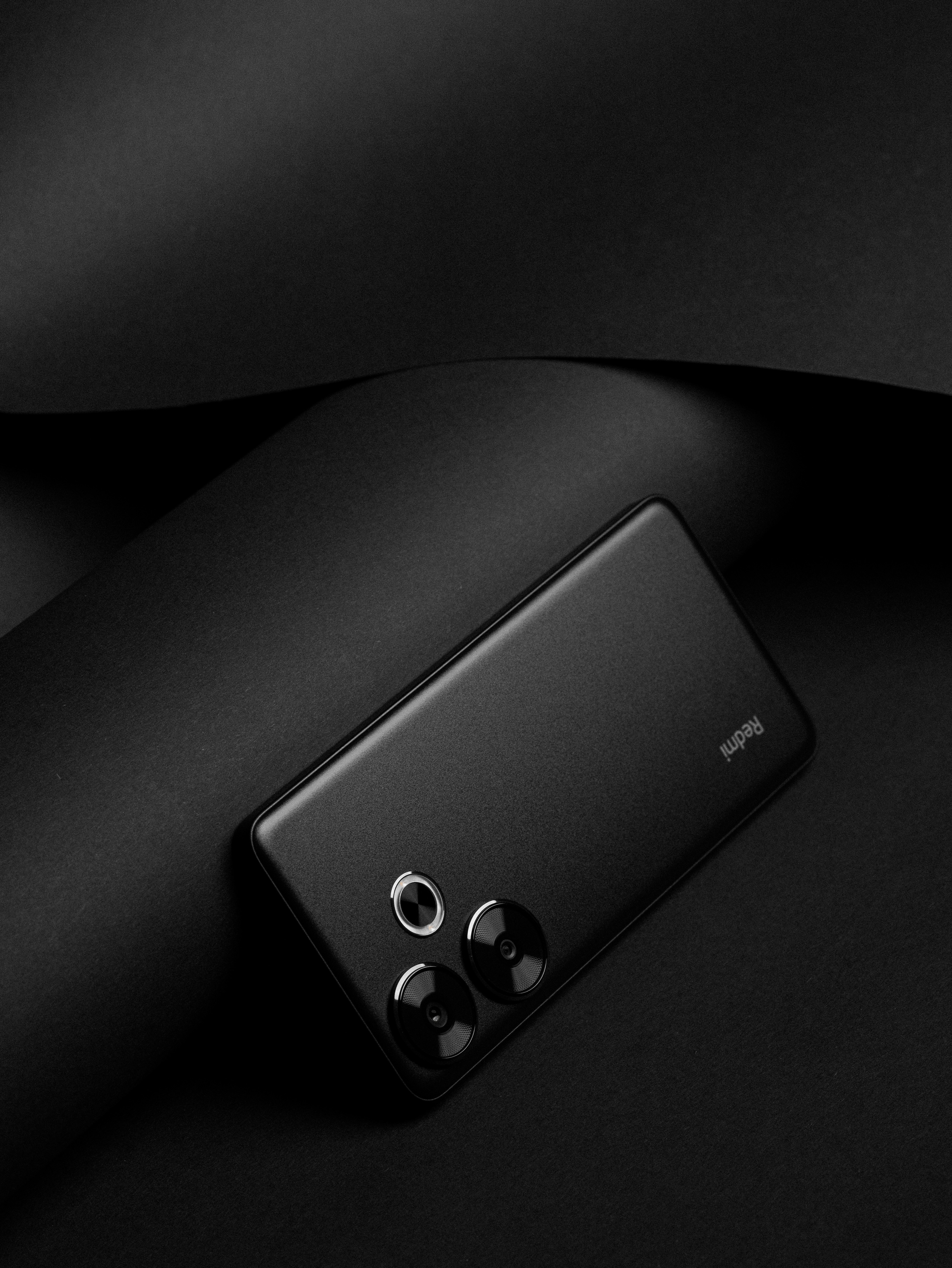Modern black smartphone displayed on a dark, minimalist background.