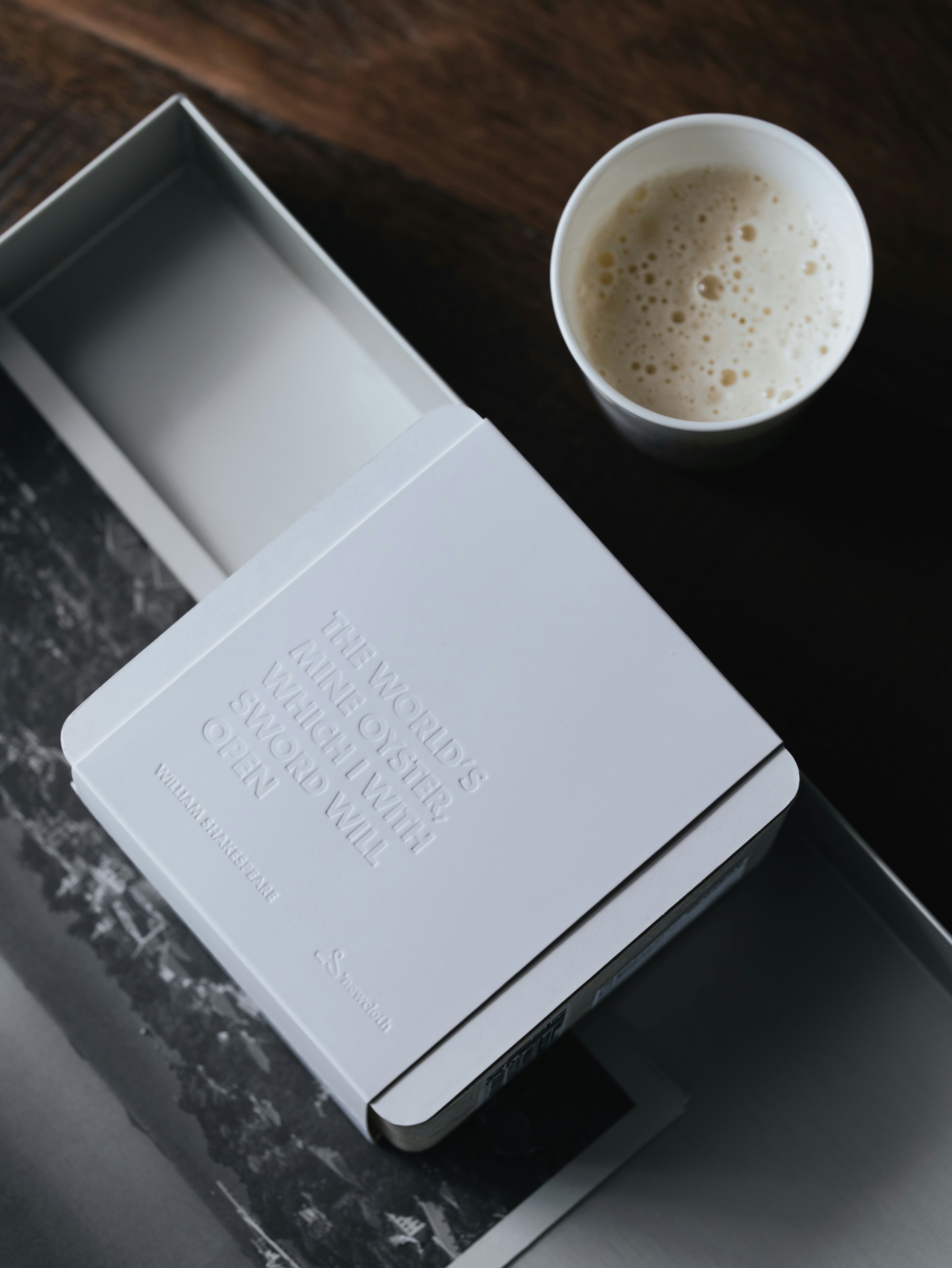 White card box and coffee cup on a dark wooden table