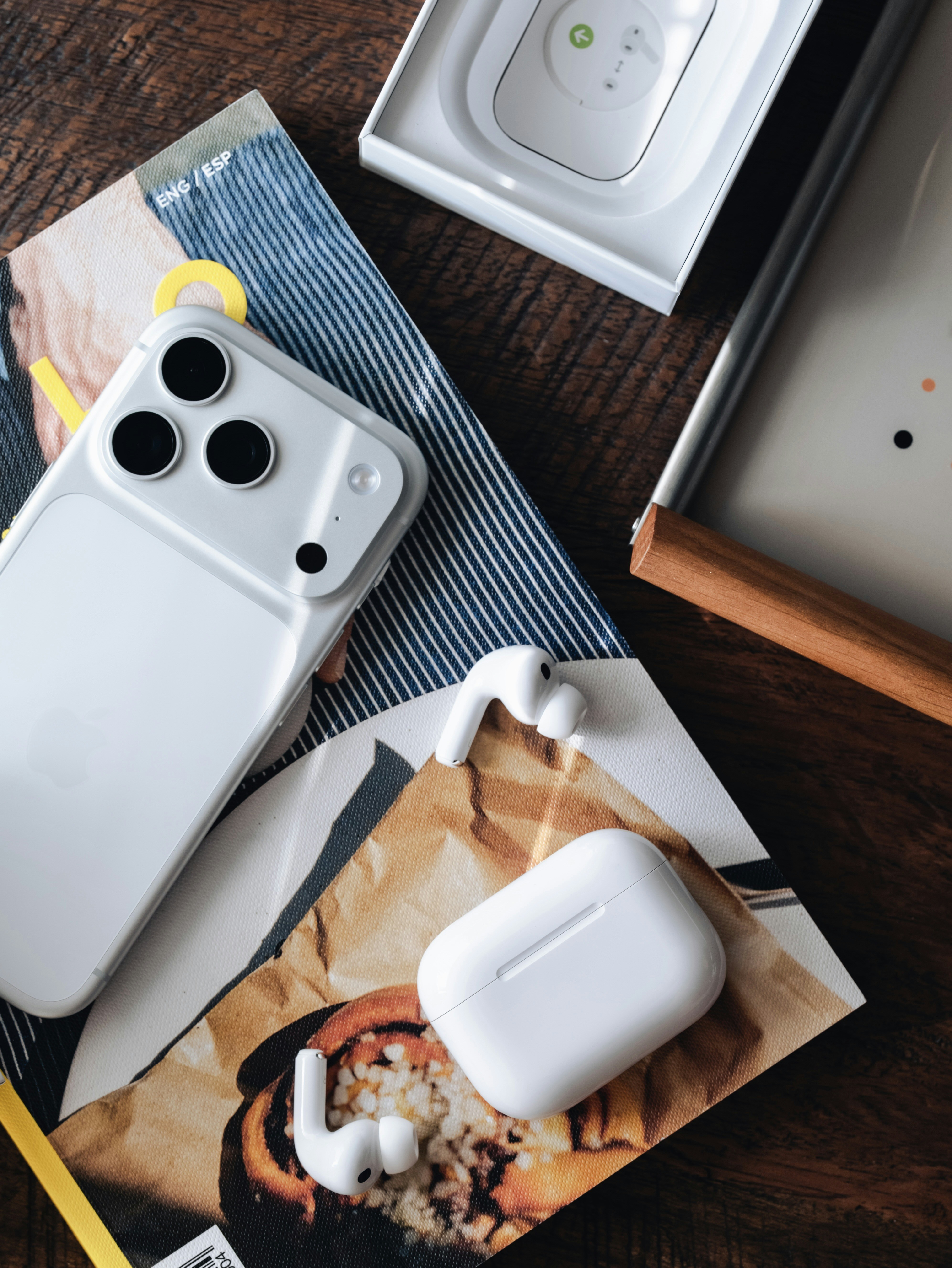 White iPhone Pro with AirPods and Case on a Stylish Desk Setup