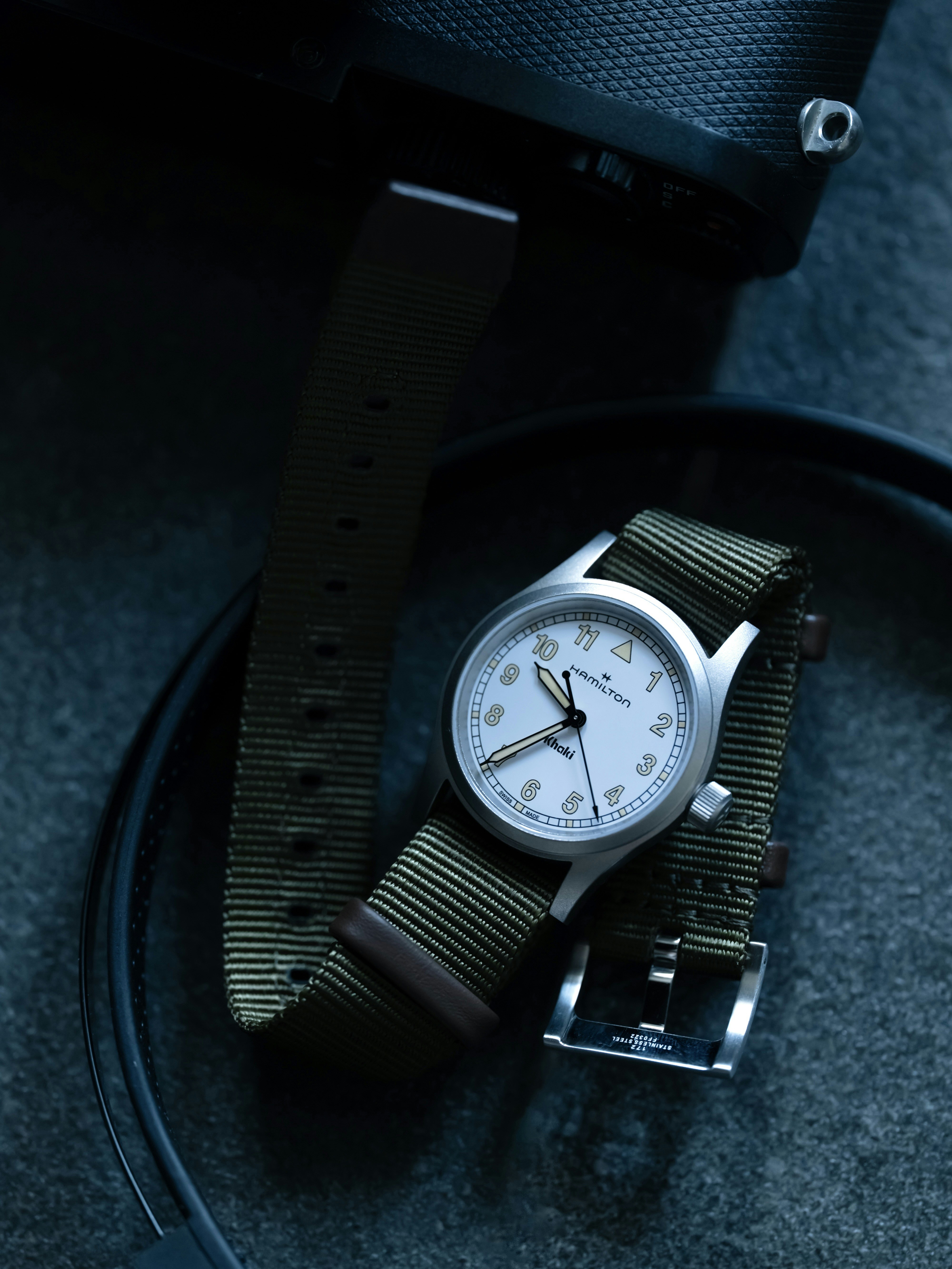 A vintage-style watch with a green nylon strap.