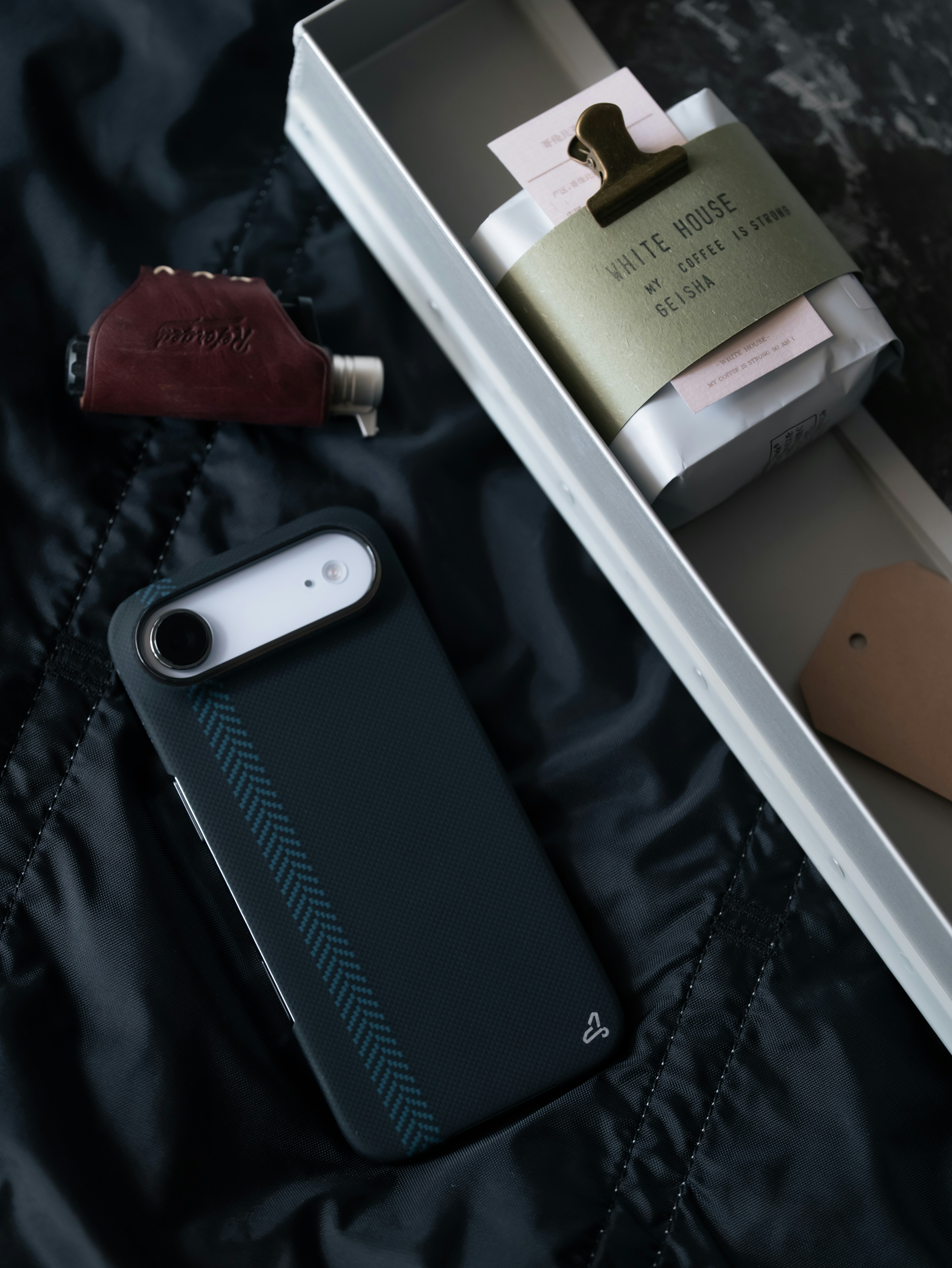 Tech Noir: A Studio Setup with a Leather Grip and a Smartphone Case