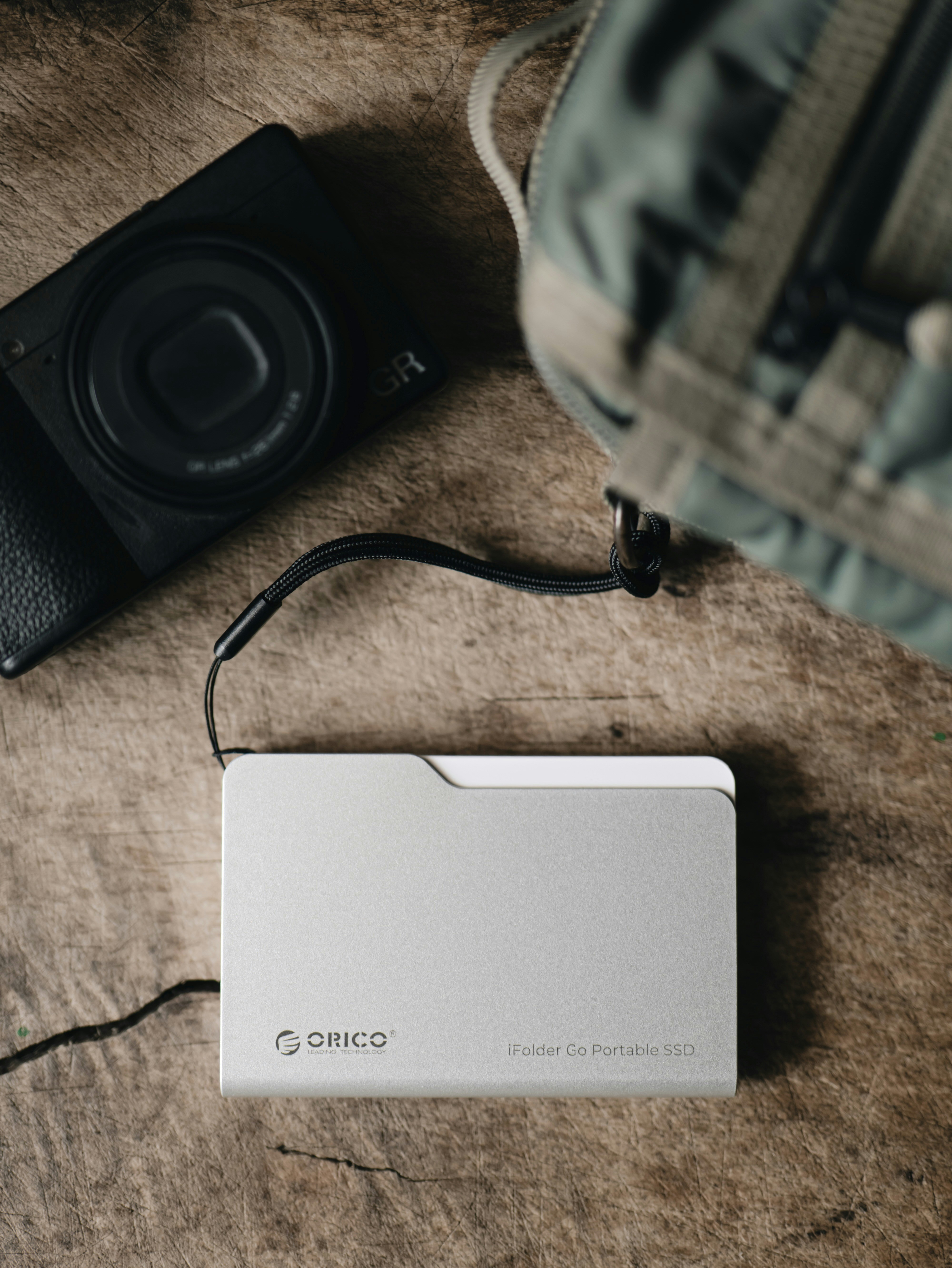 Camera and portable hard drive on wooden table