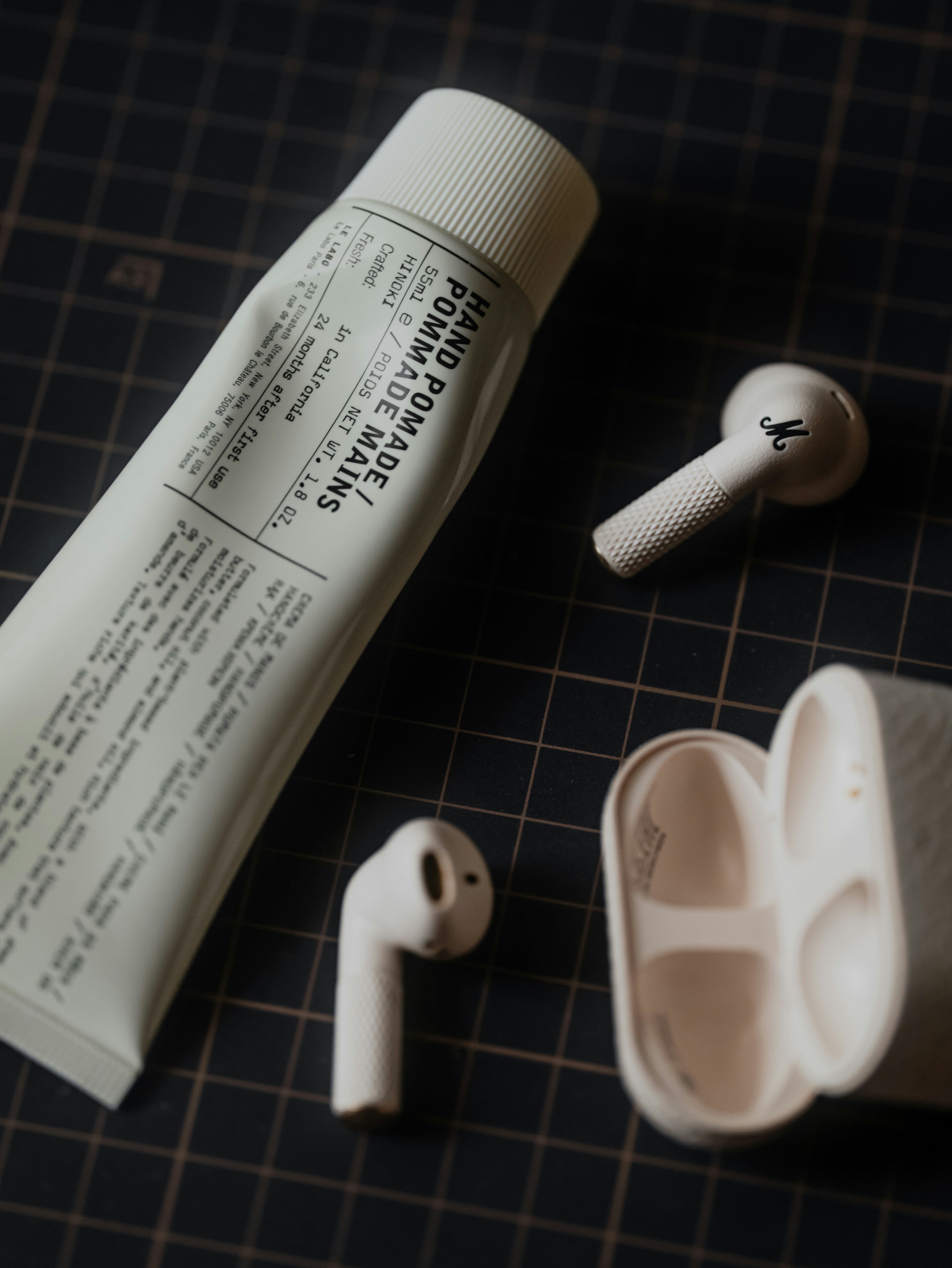 Precision in a Drop: A Minimal Studio of Earbuds and Cleaner Tube