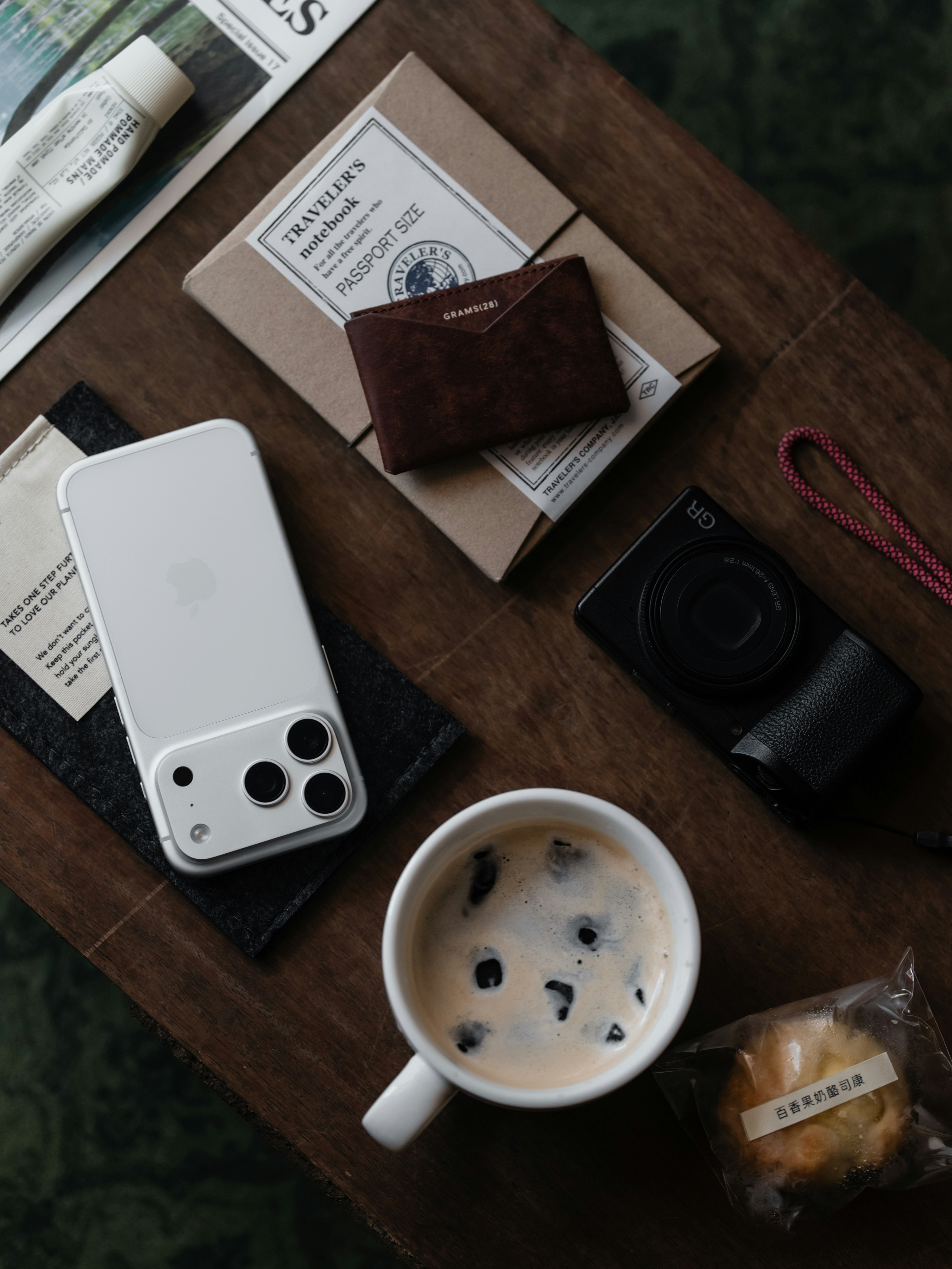 Flat lay of smartphone, camera, coffee, and notebook.
