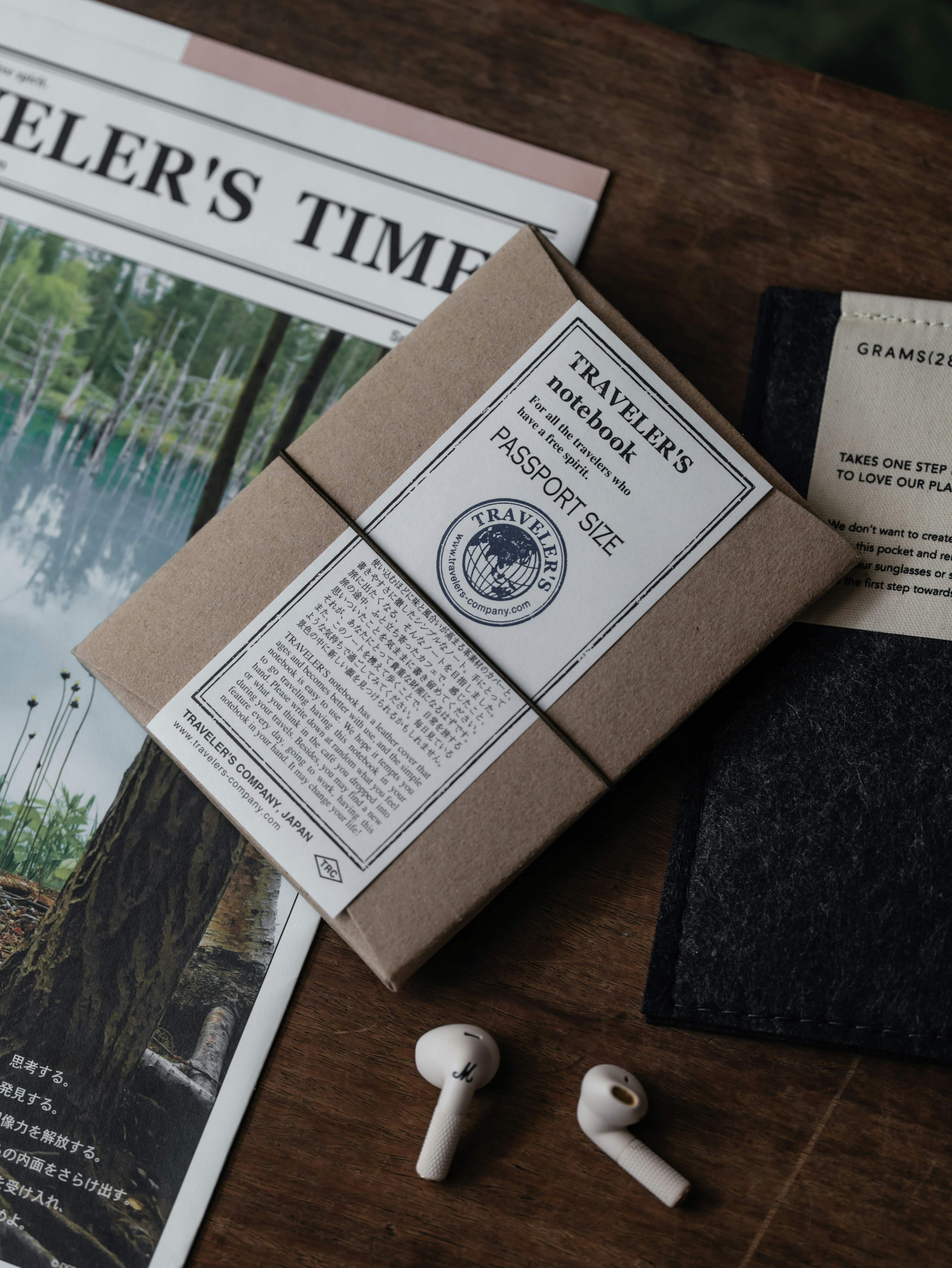 Traveler's Quiet Collage: Passport, Paper, and Earbuds on a Wood Table