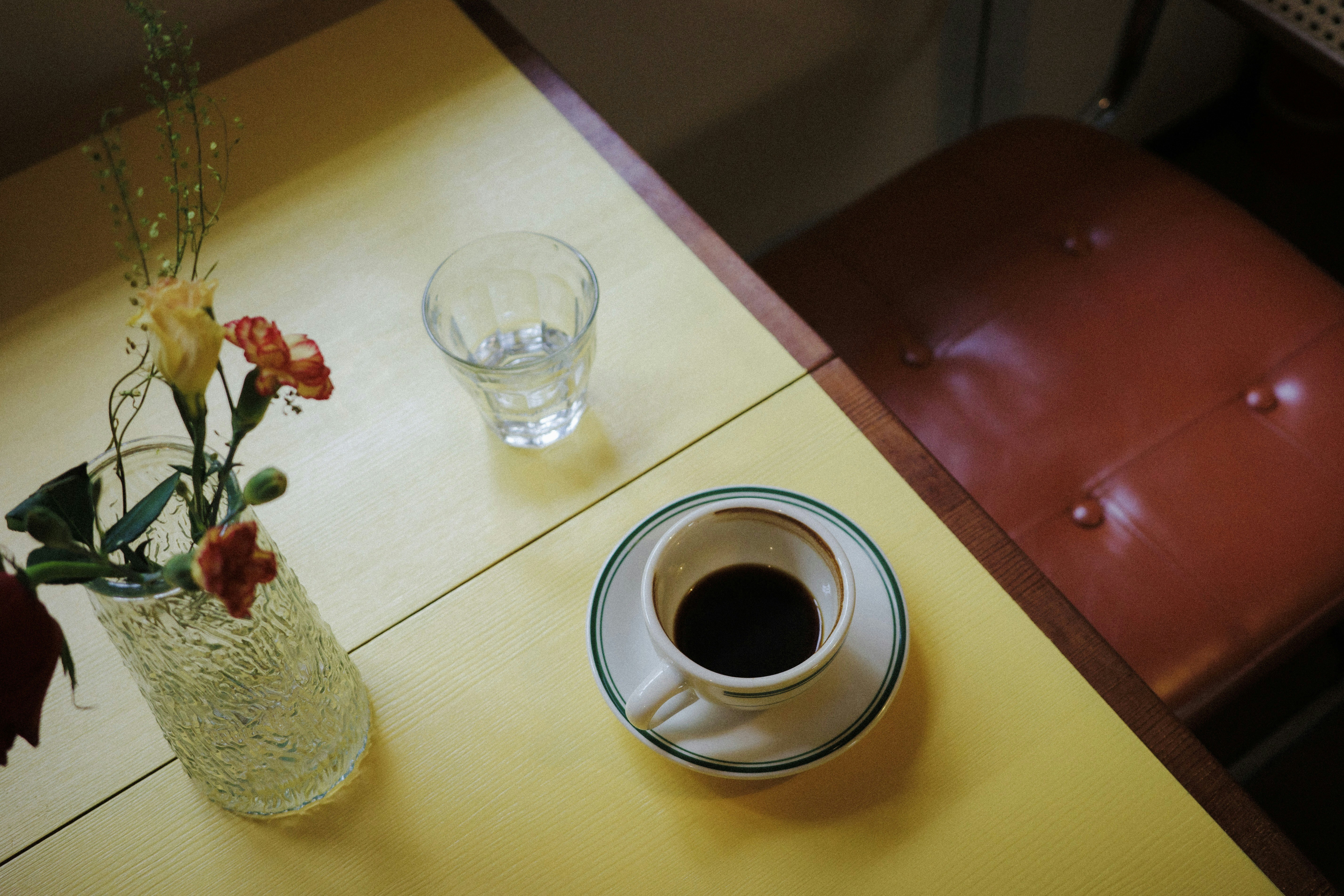 Ceramic Cup of Black Coffee on a Sunny Caf%C3%A9 Table with Fresh Flowers