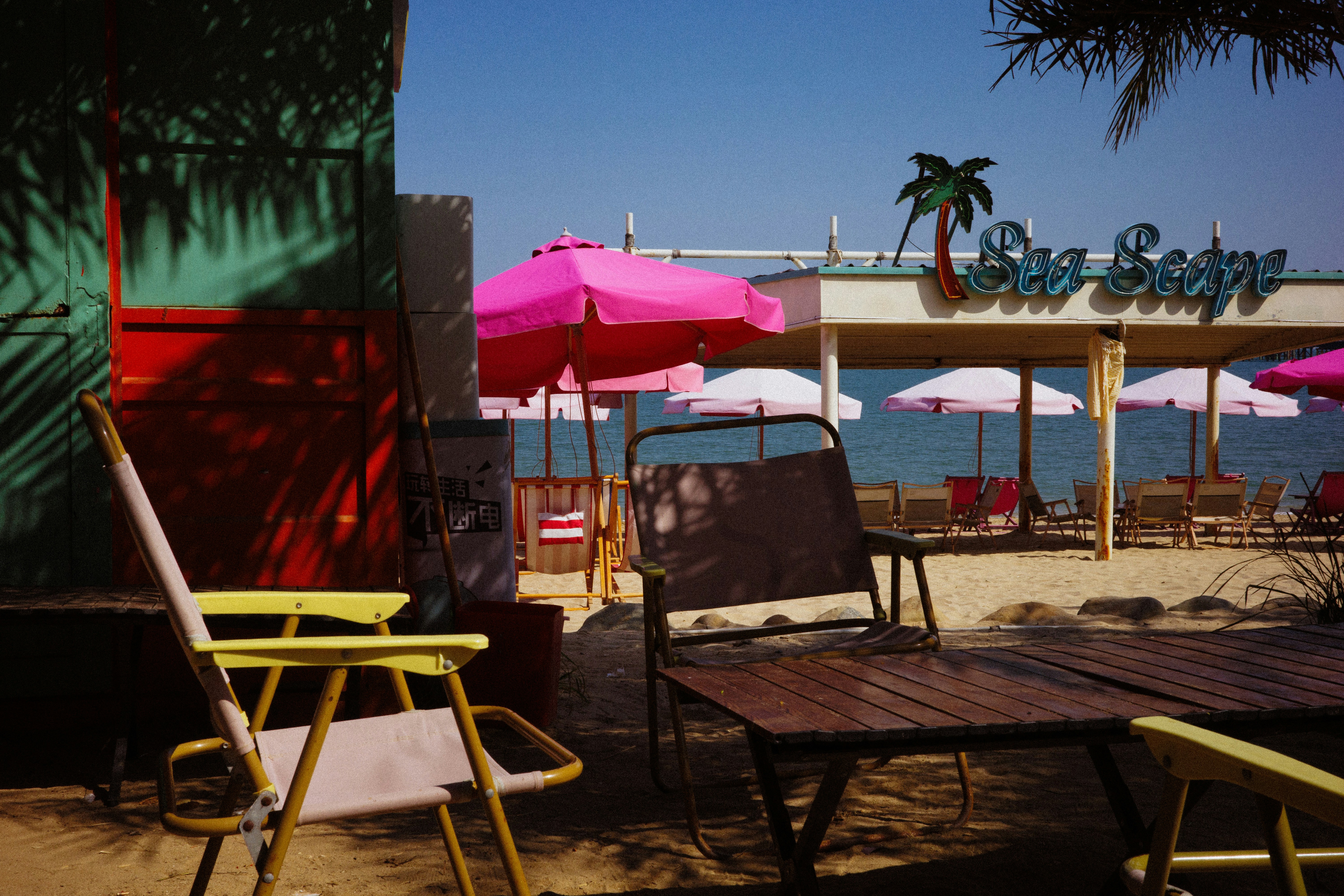Pink Parasols and Sea-Front Chairs at Dusk Beach Club