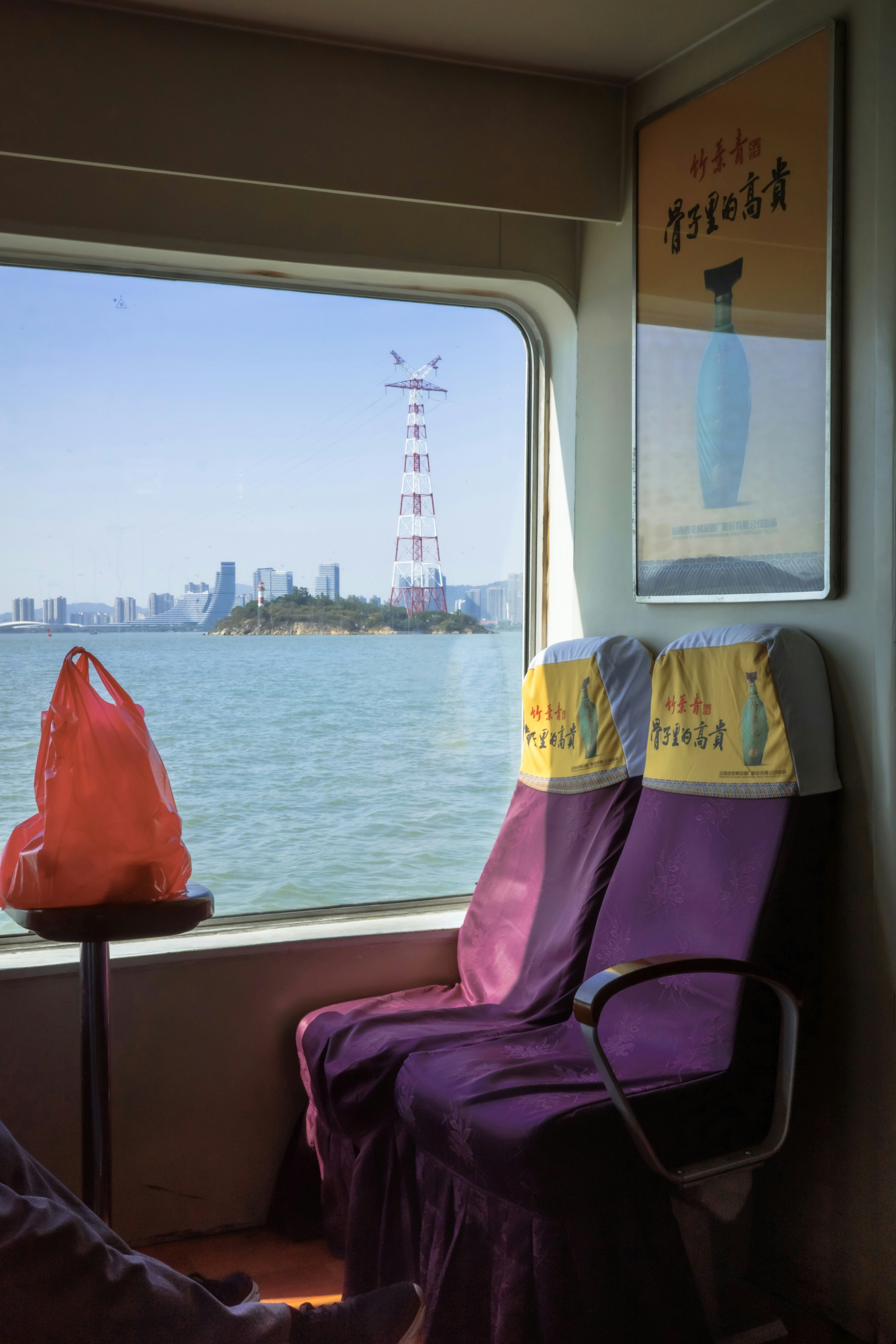 Window Seat Overlooking the Waterfront: Purple Chairs and Red Bag in Soft Light