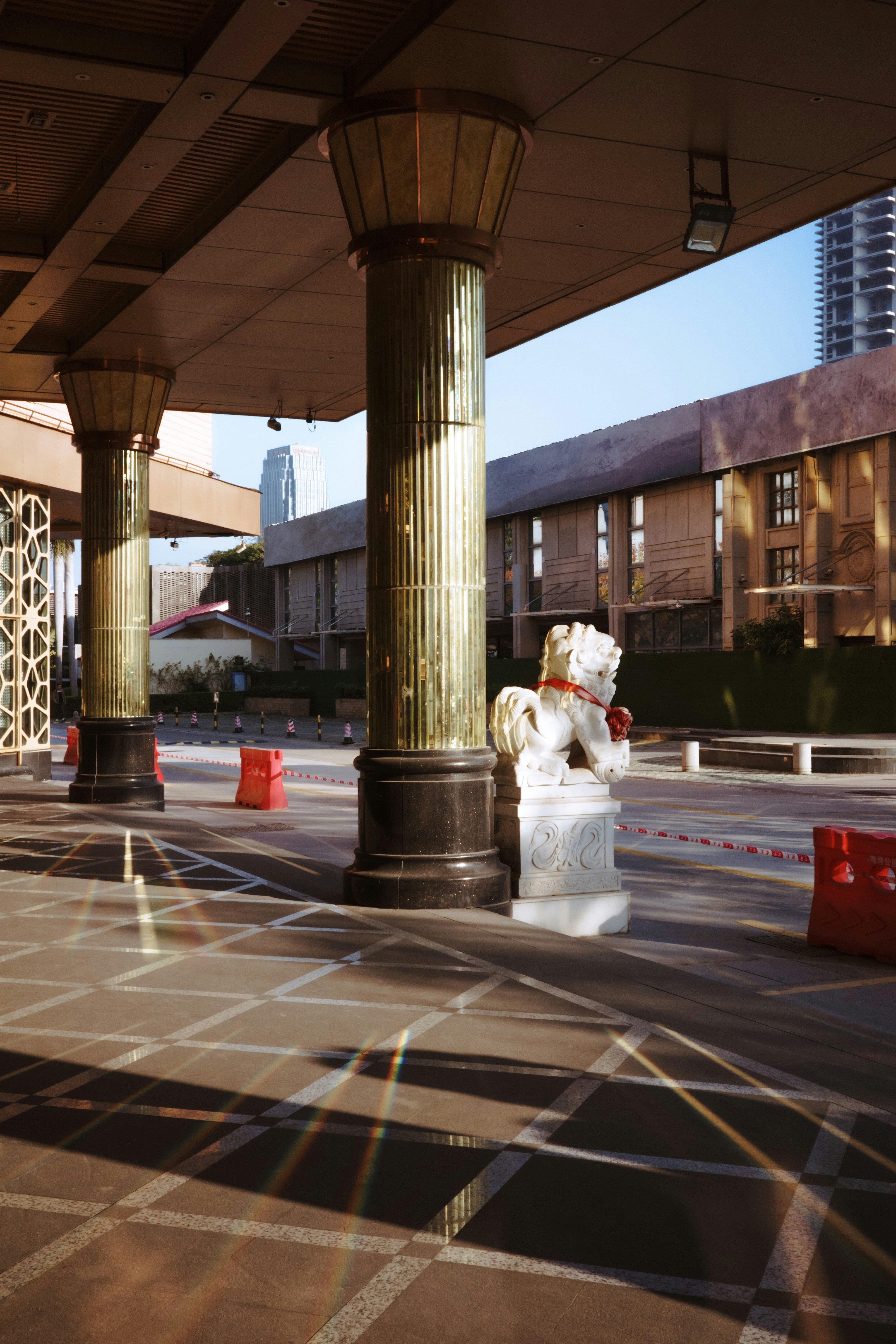 Columned Canopy and Guardian Lion: Geometry, Shadow, and Neon Reflections