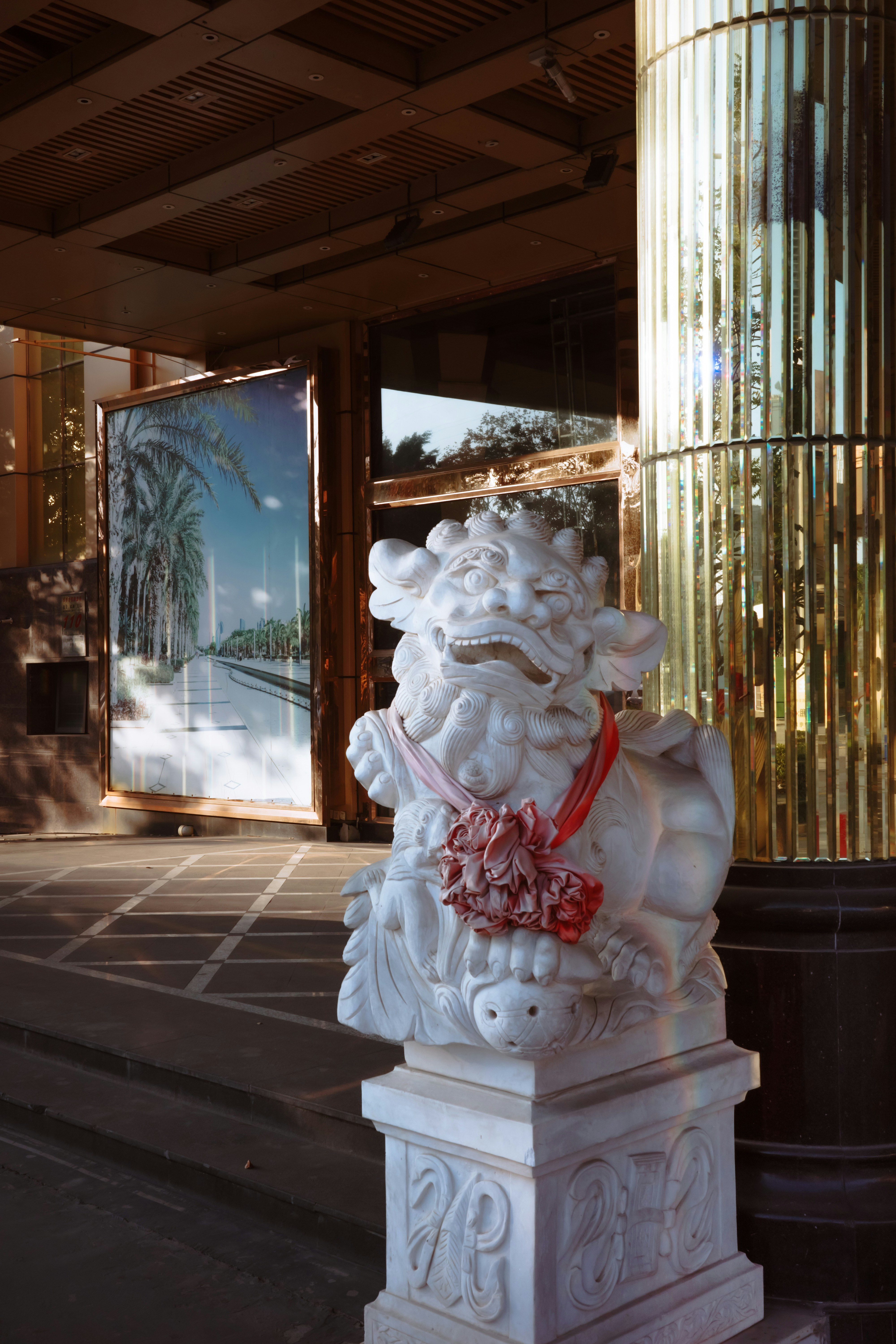 Guardian in Front of Glass: A Stone Lion with Coral Ribbon
