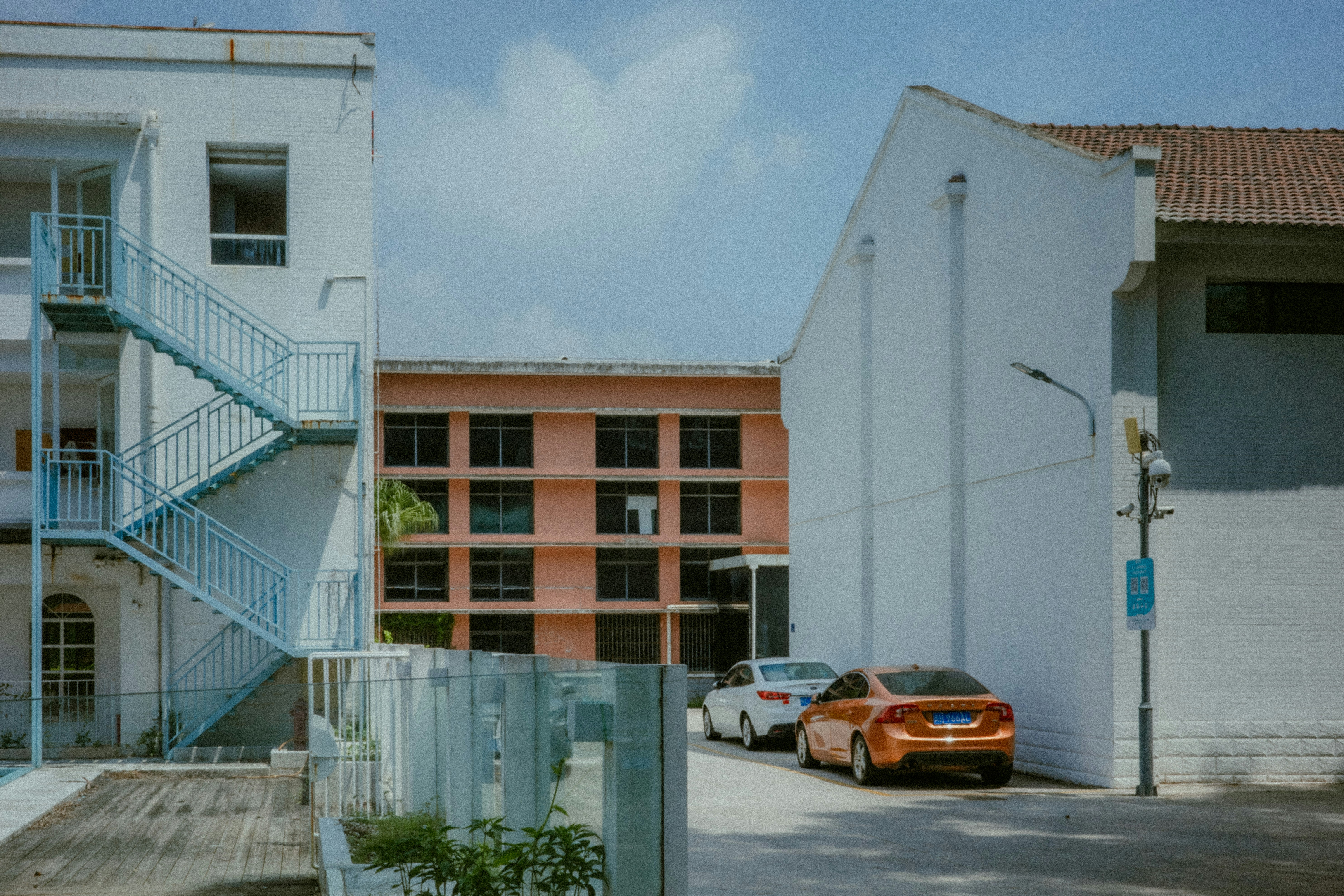 Orange Car at the Quiet Corner of an Industrial Street