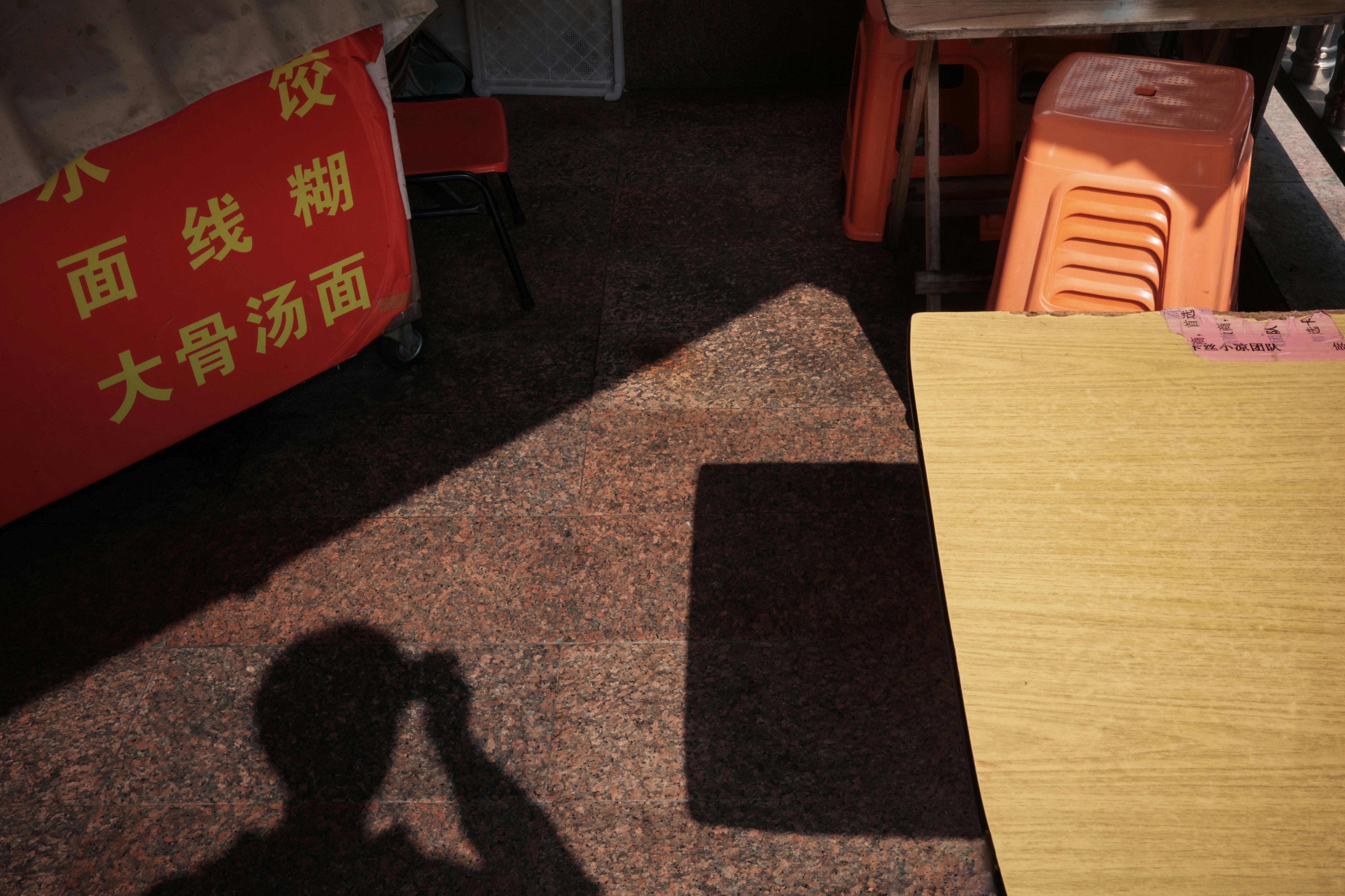 Shadow of person on a textured floor next to furniture