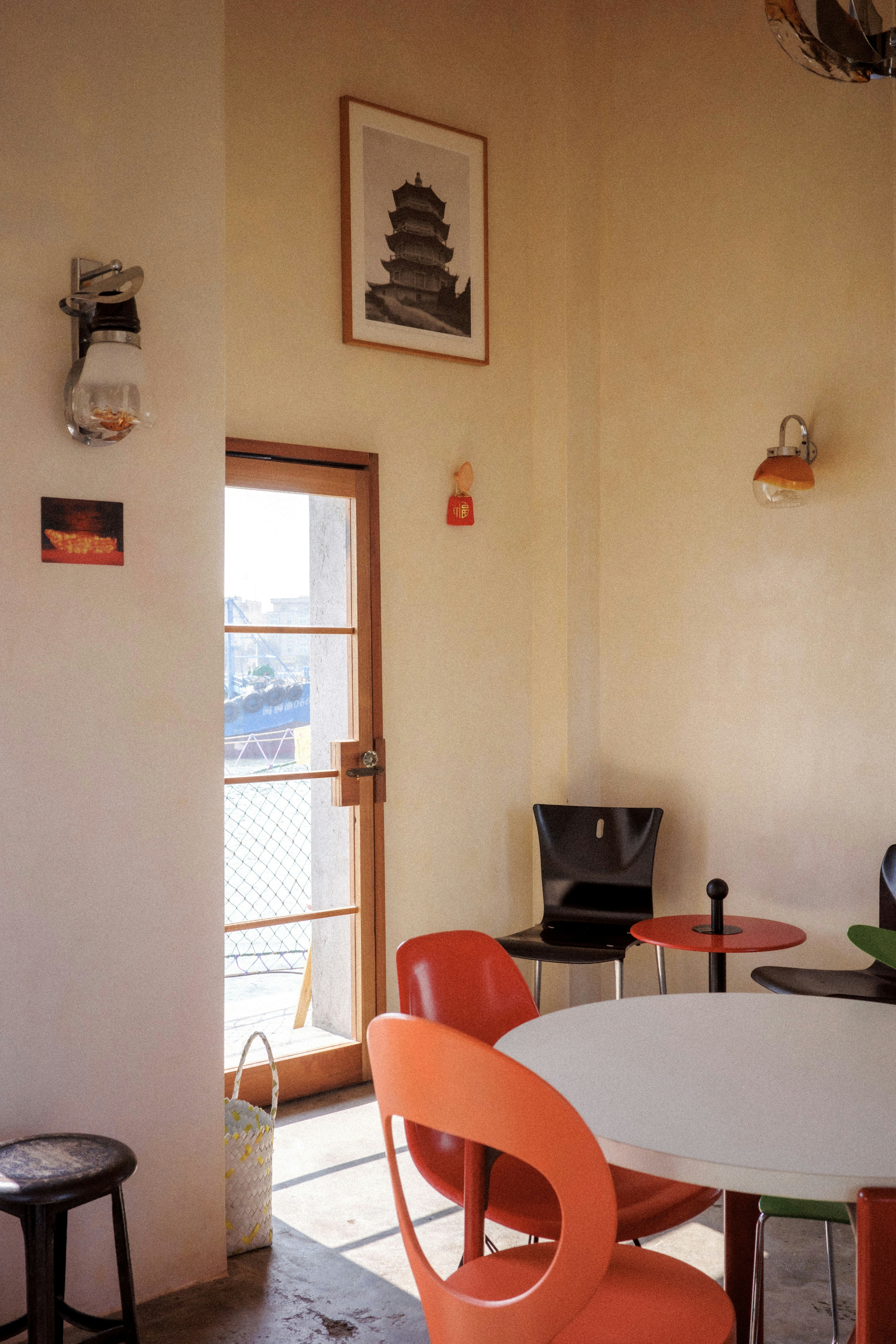Sunlit Minimal cafe nook with bold orange chairs