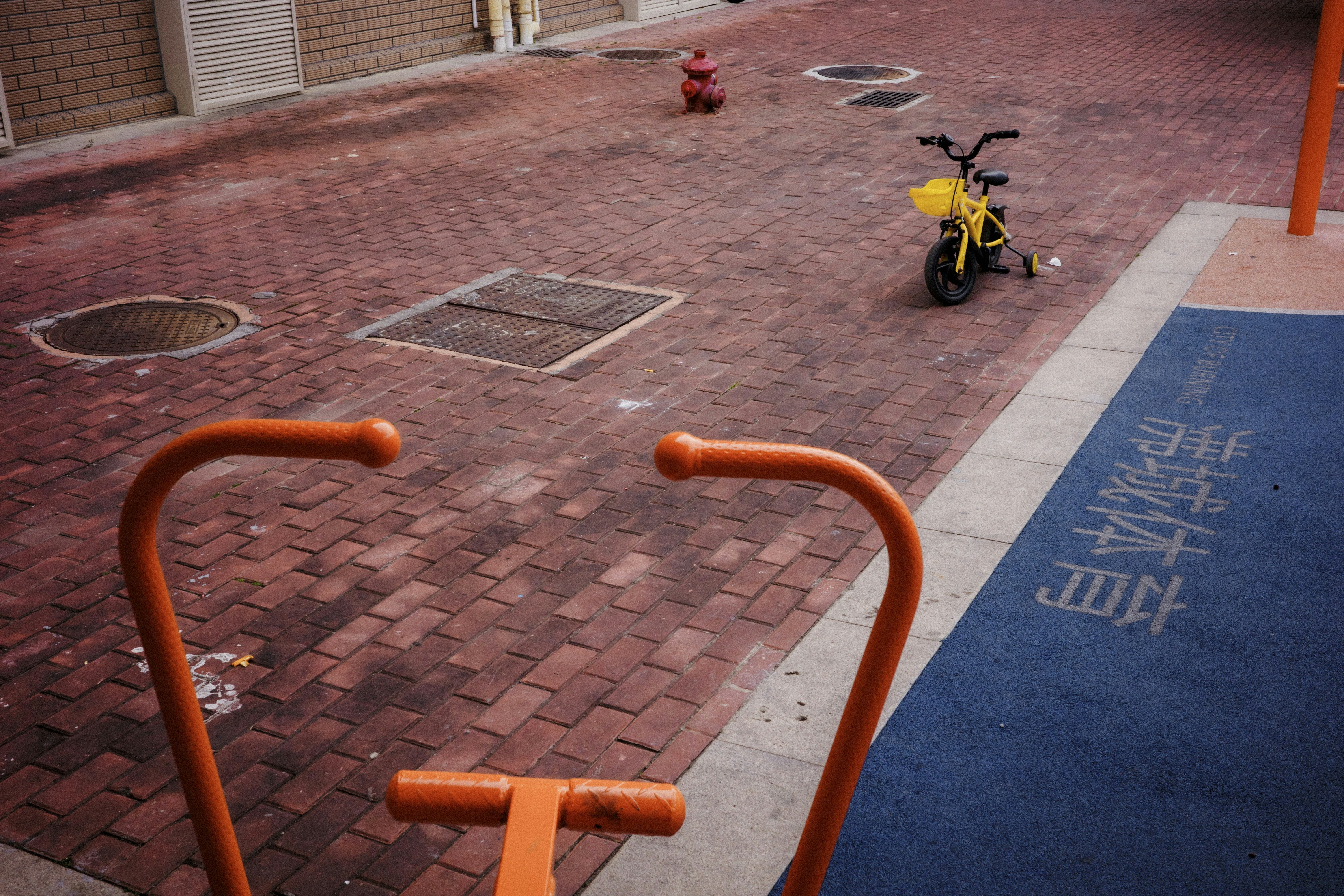 Bright Orange Rails Lead to a Tiny Yellow Bike