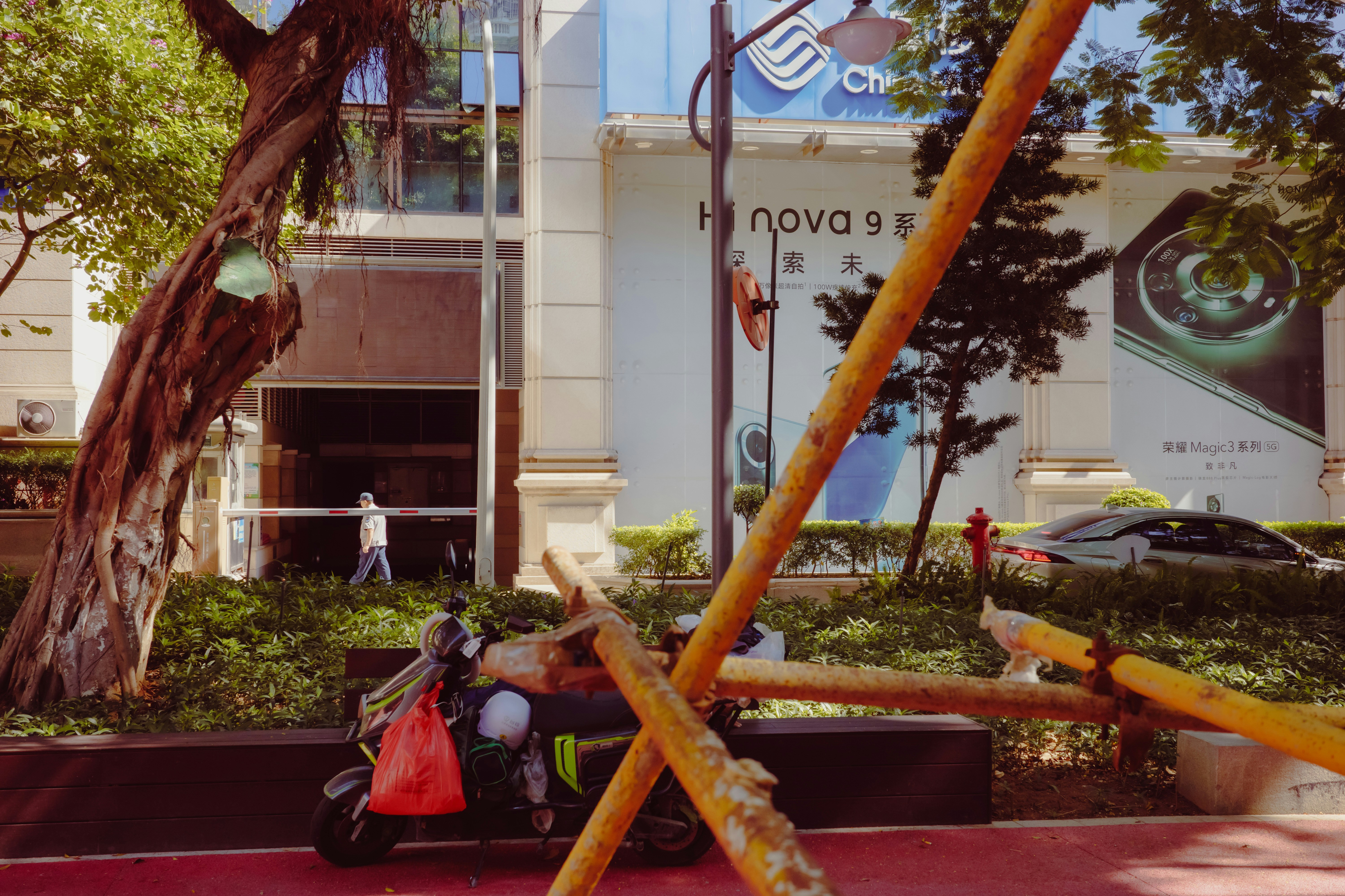 Urban Quiet Under Construction: A Scooter Restes by Red Sidewalk