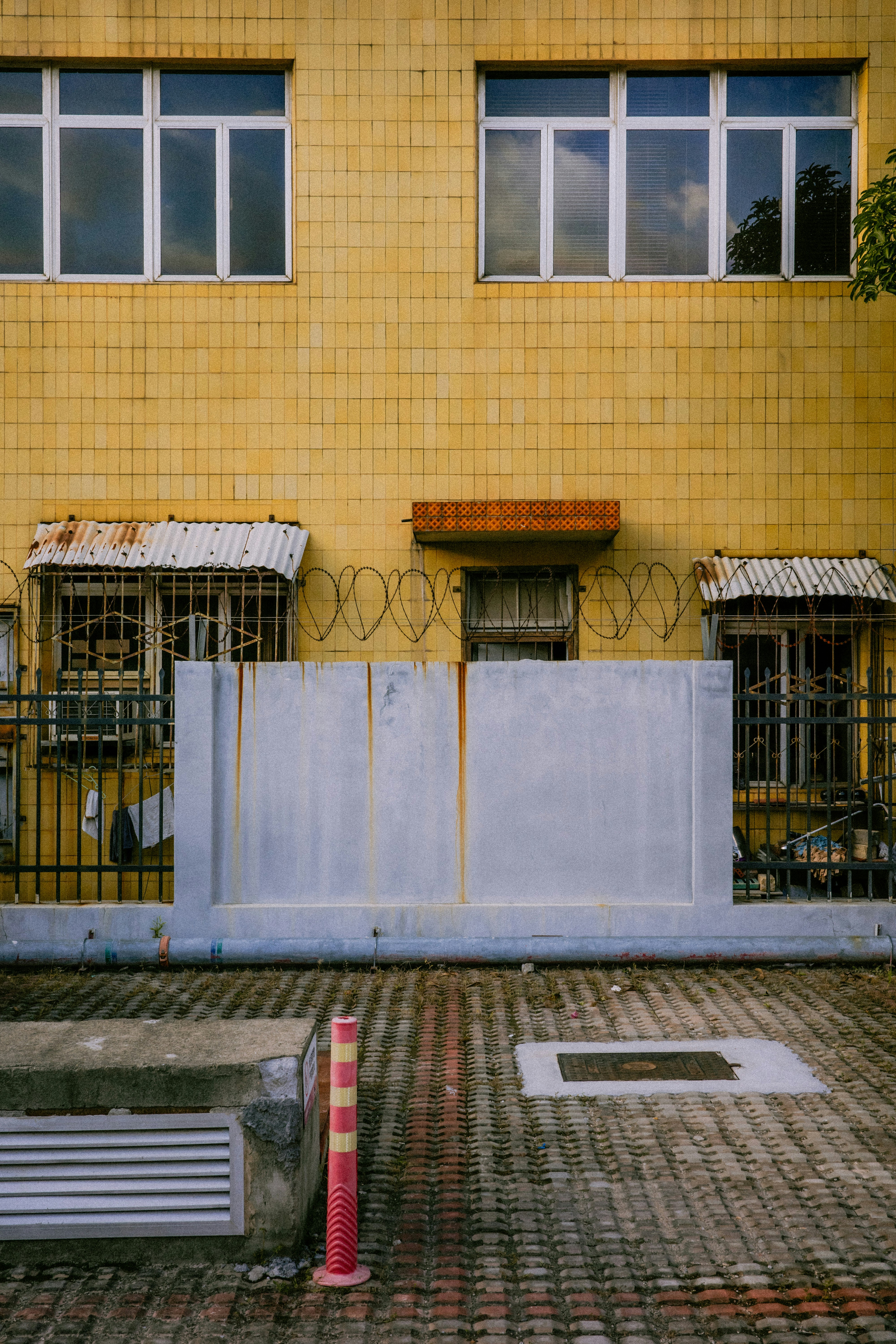 Yellow Facade, Barbed Wall, and Worn Shield