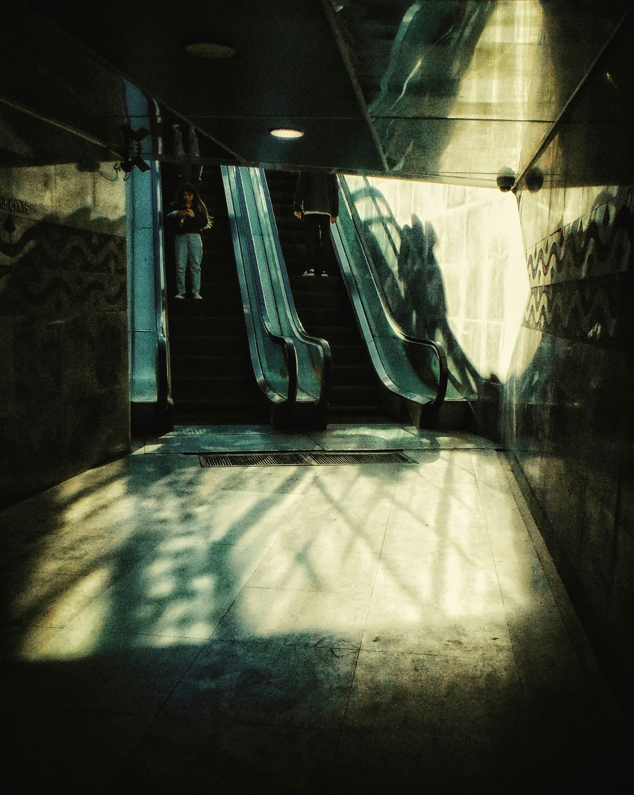 Escalator Shadows in a Dim Subway Corridor