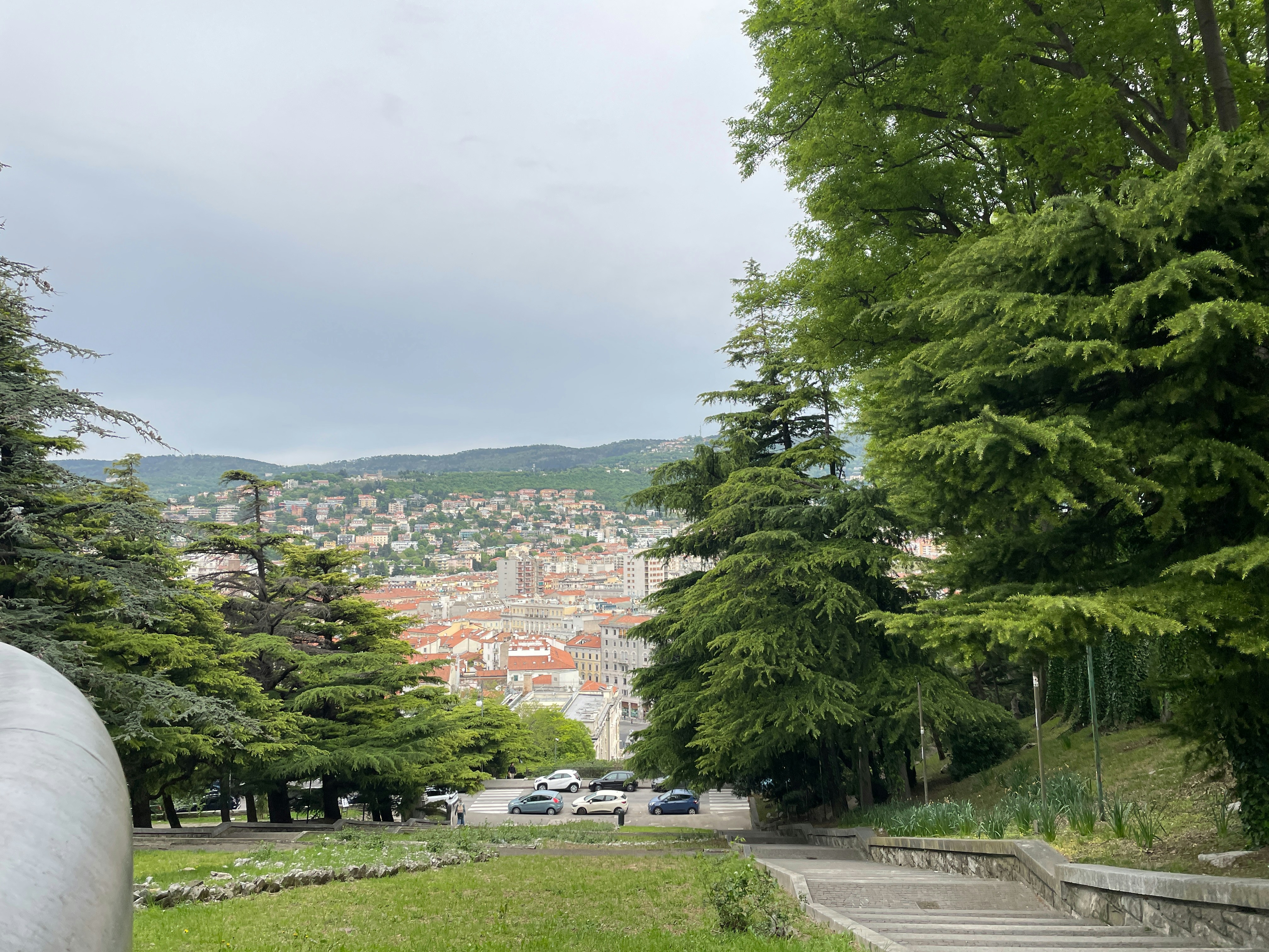 Alpine Vantage: Cars at the Foot of a Green Terrace