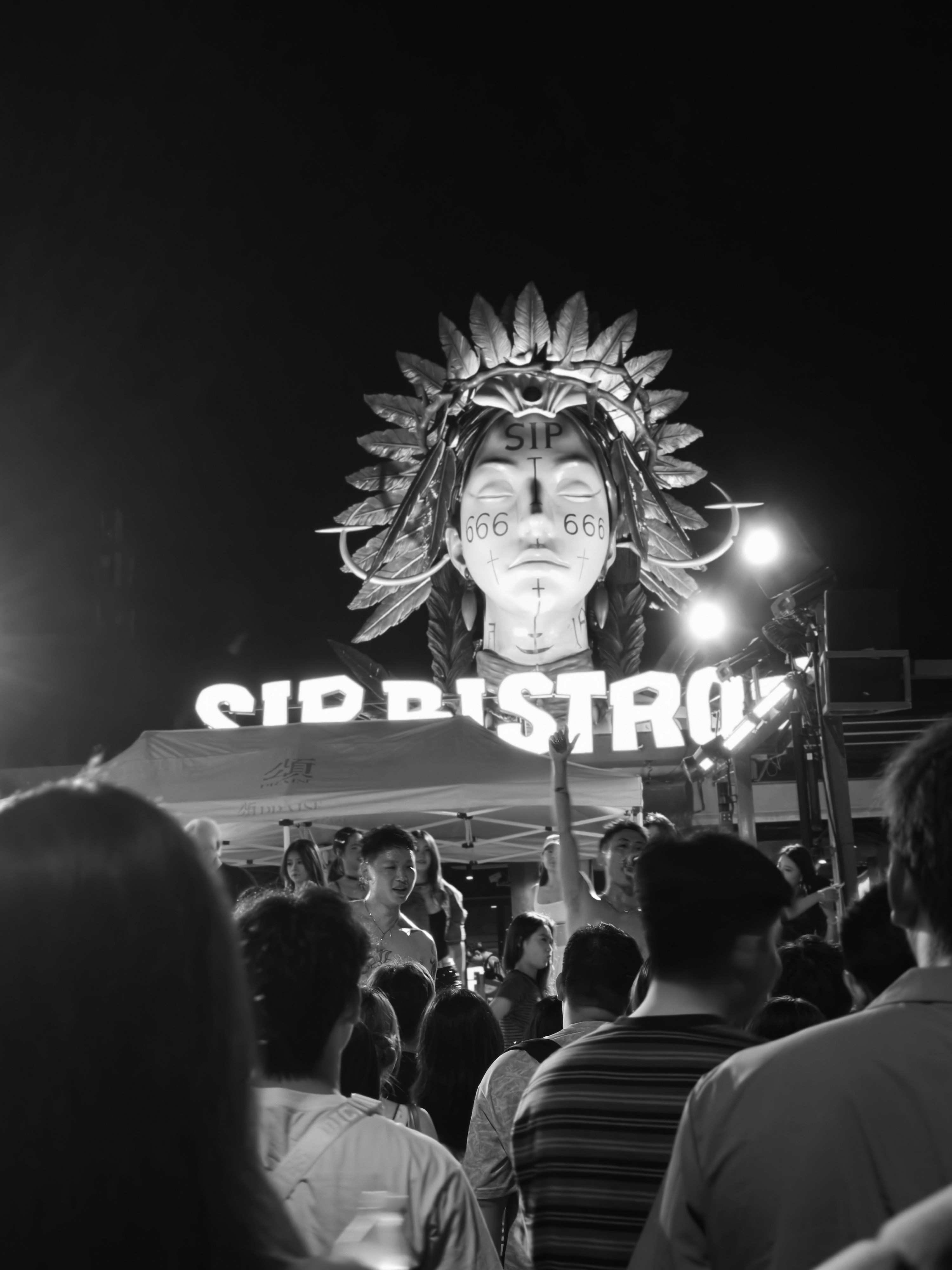 Night at the Carnival: Giant Mask Overlooks the Crowd
