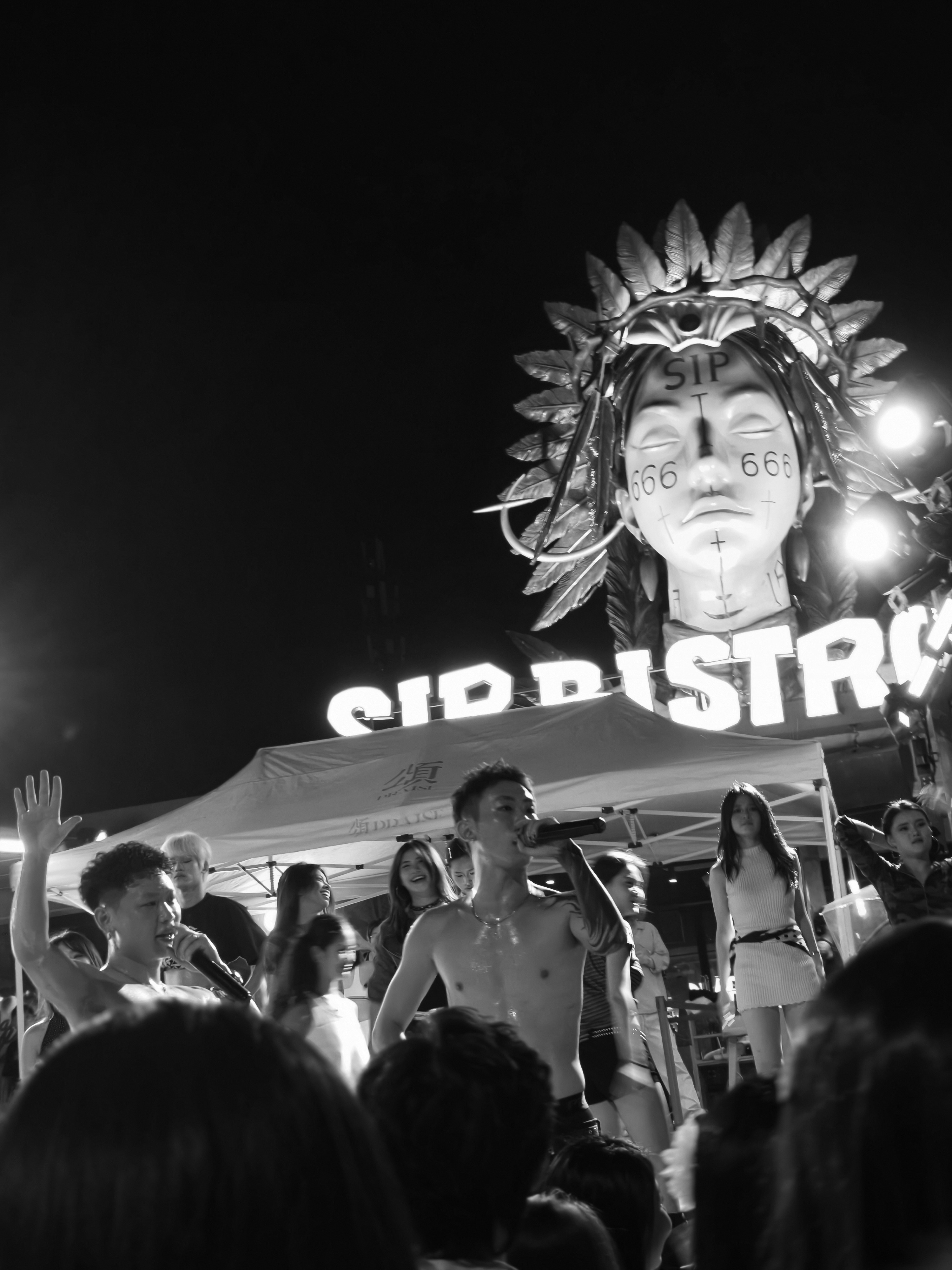 Night at the Carnival: Giant Mask and Neon Sign Overshadow the Stage
