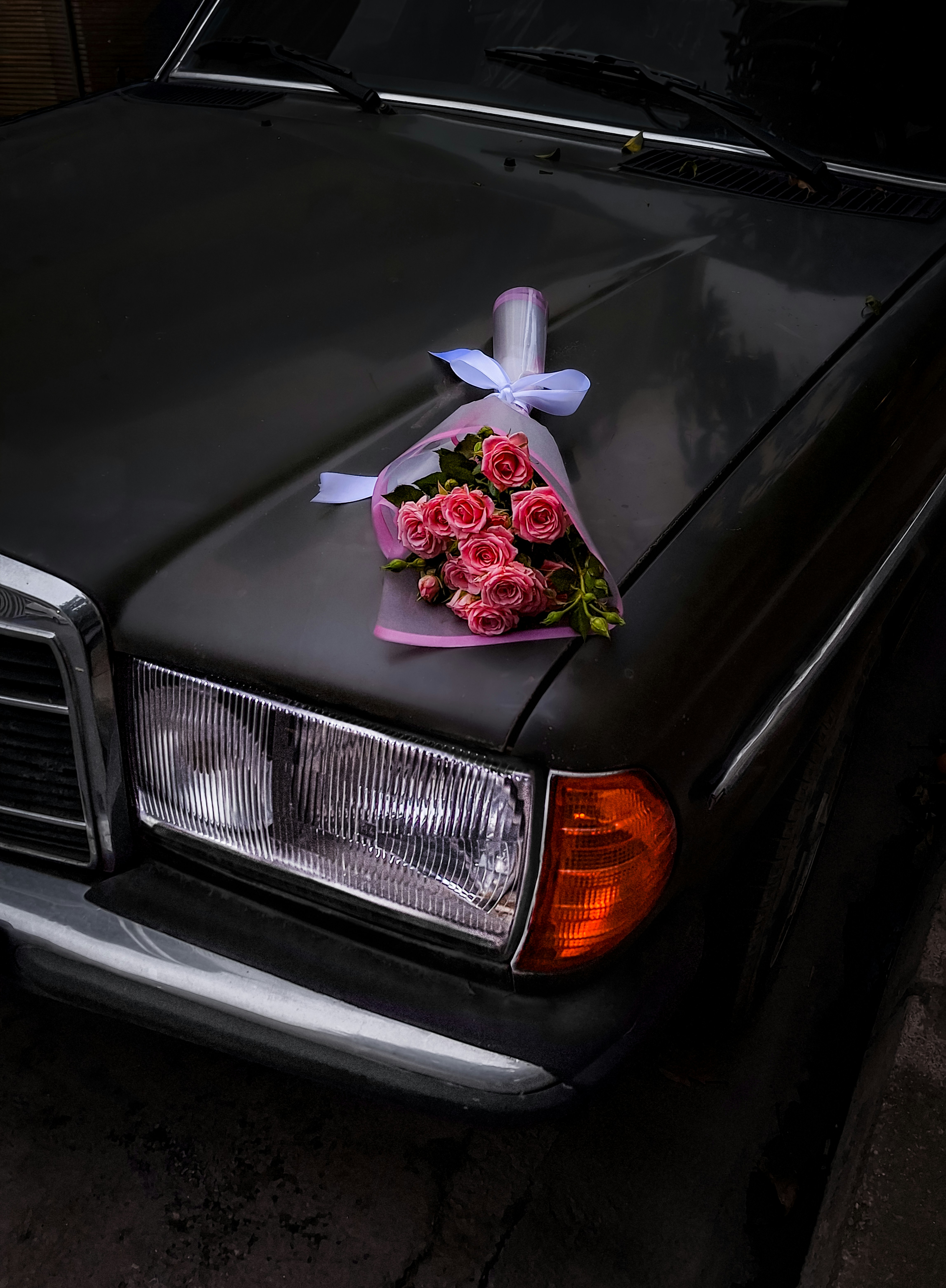 Bouquet on the Hood: A Quiet Anniversary on a Dark Panel