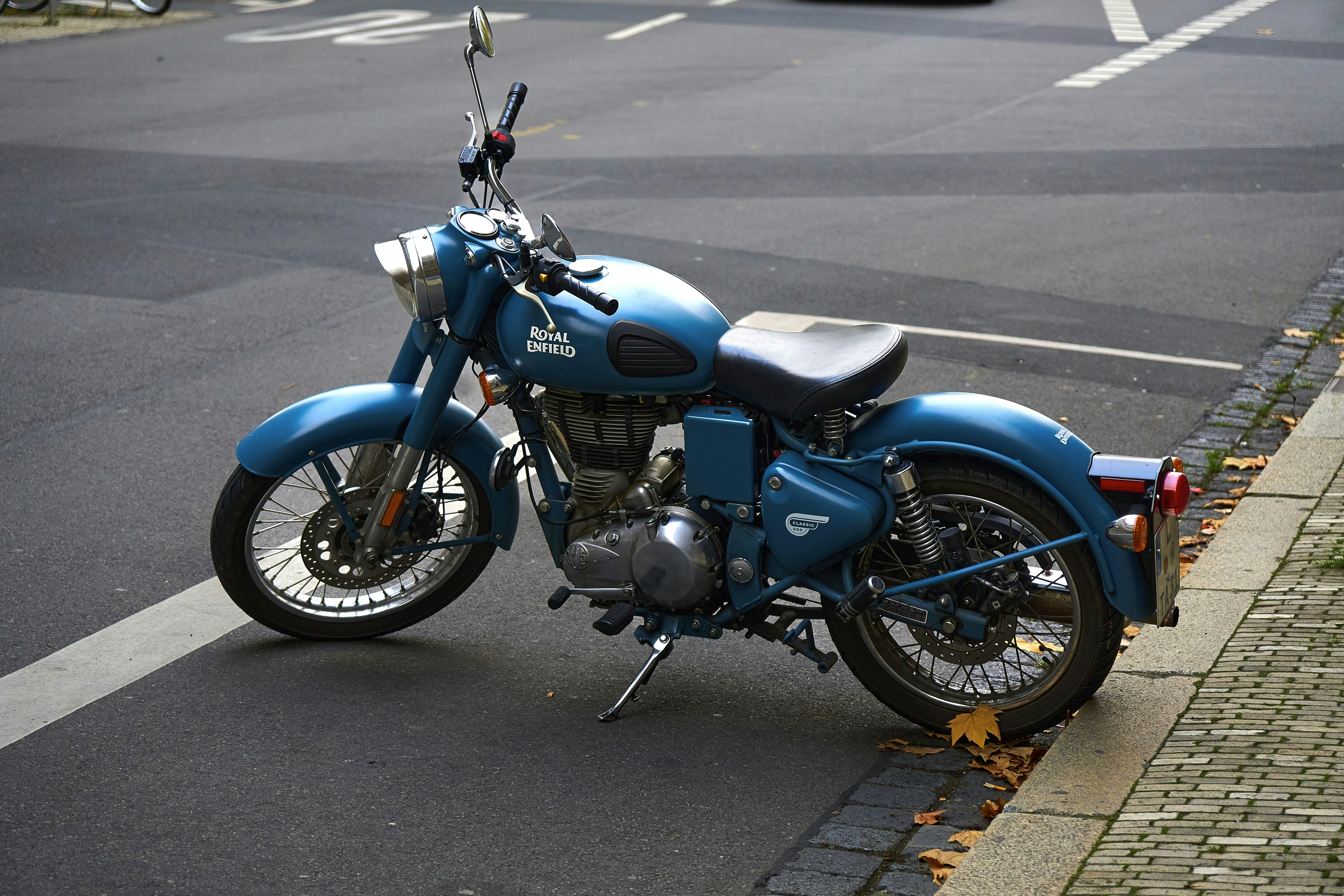 Blue Classic: A Retro Royal Enfield Stands Quietly by the Street