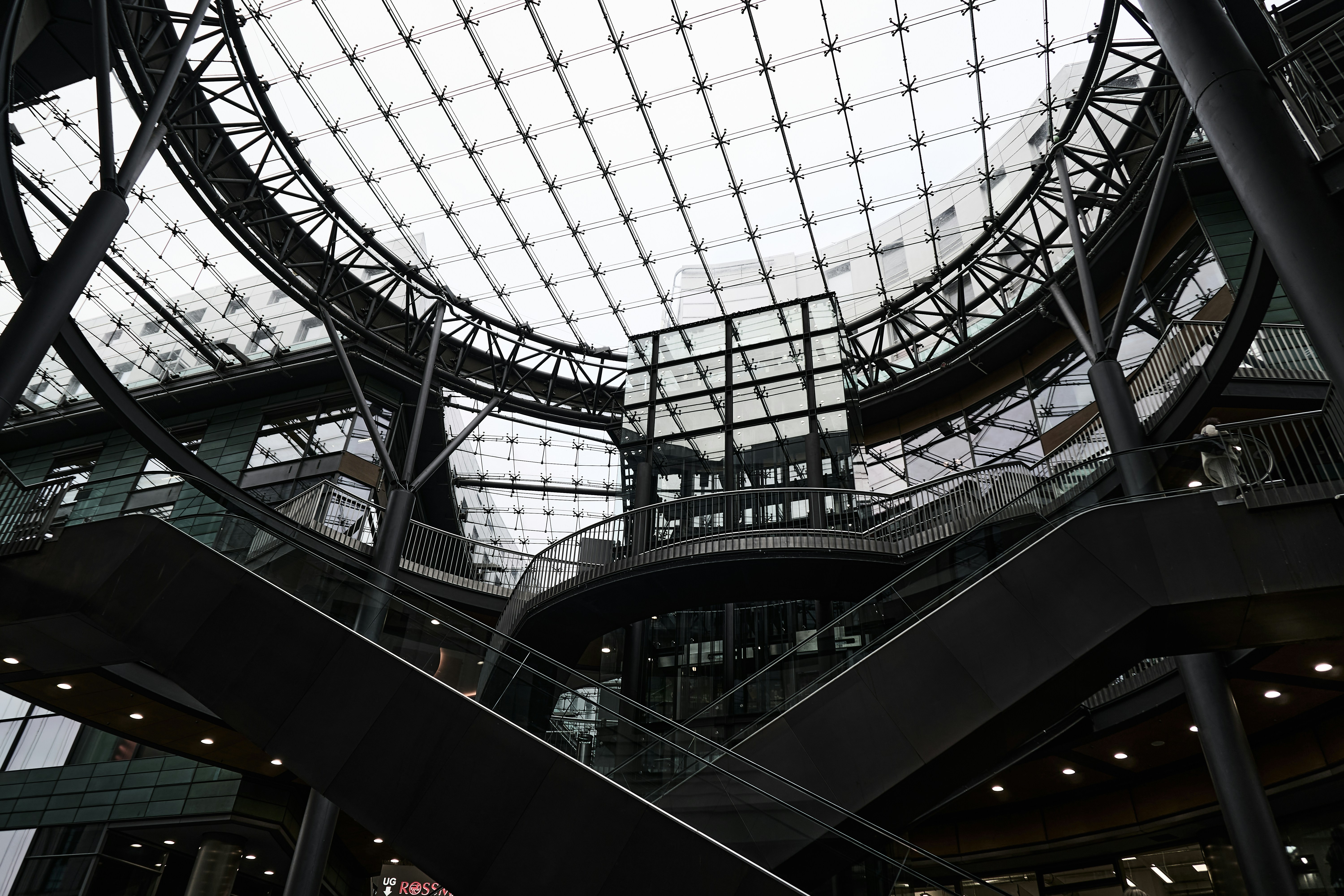 Skyframe Atrium: Glass Ceiling and Escalators Framing a Modern Atrium