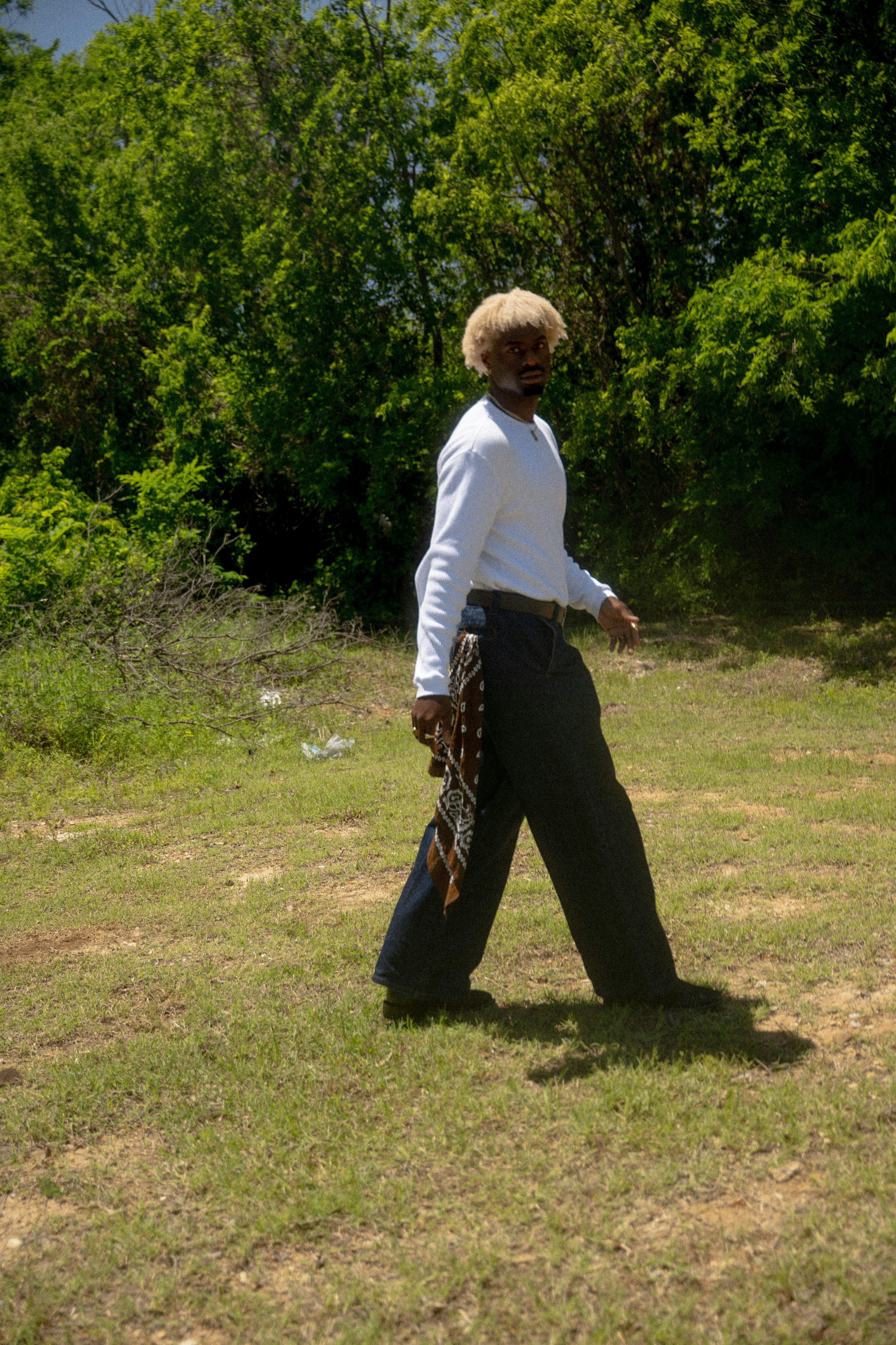 Runner in a sunlit field: contrast of white shirt and patterned scarf