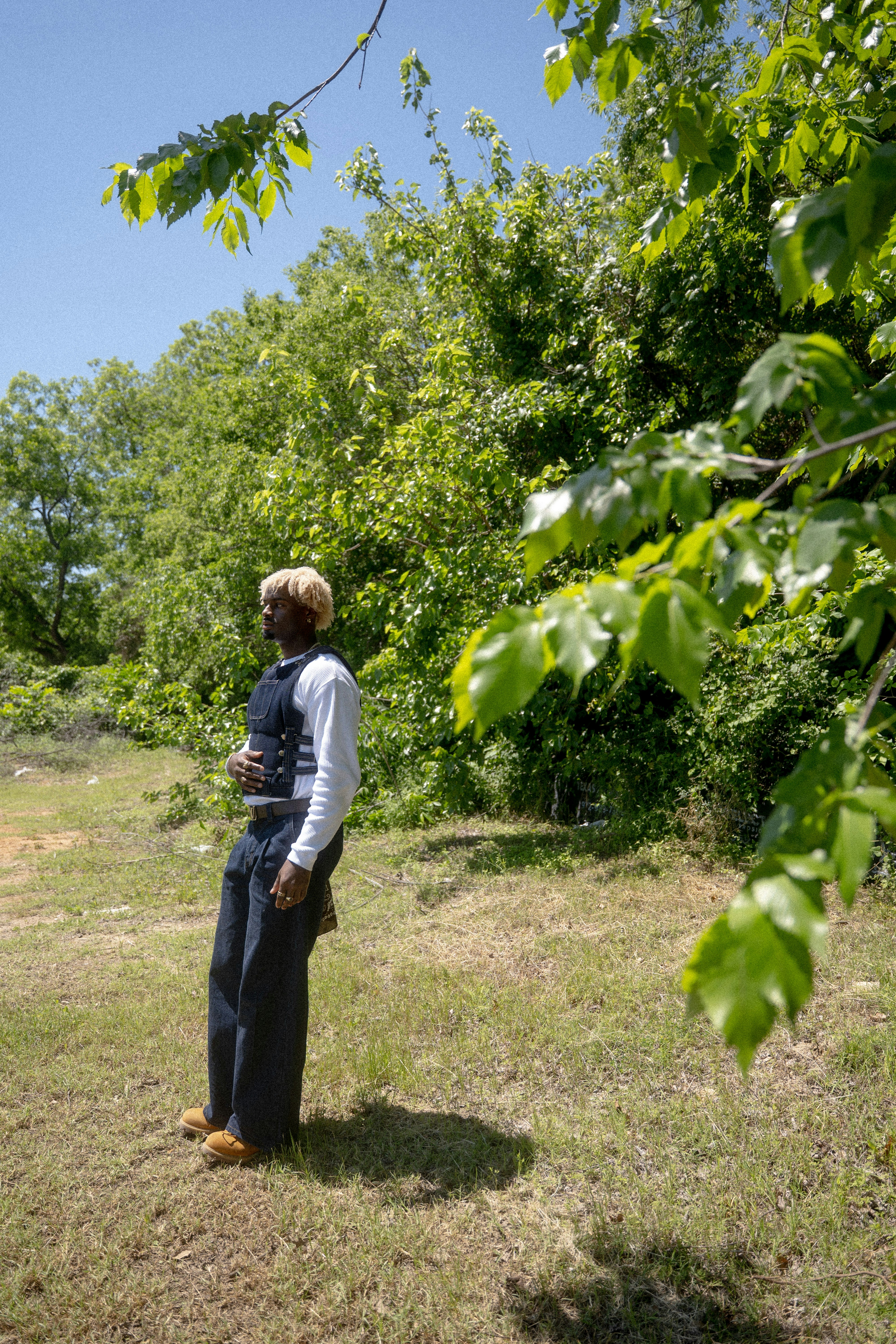 A solitary figure in a sunlit grove, poised with calm strength